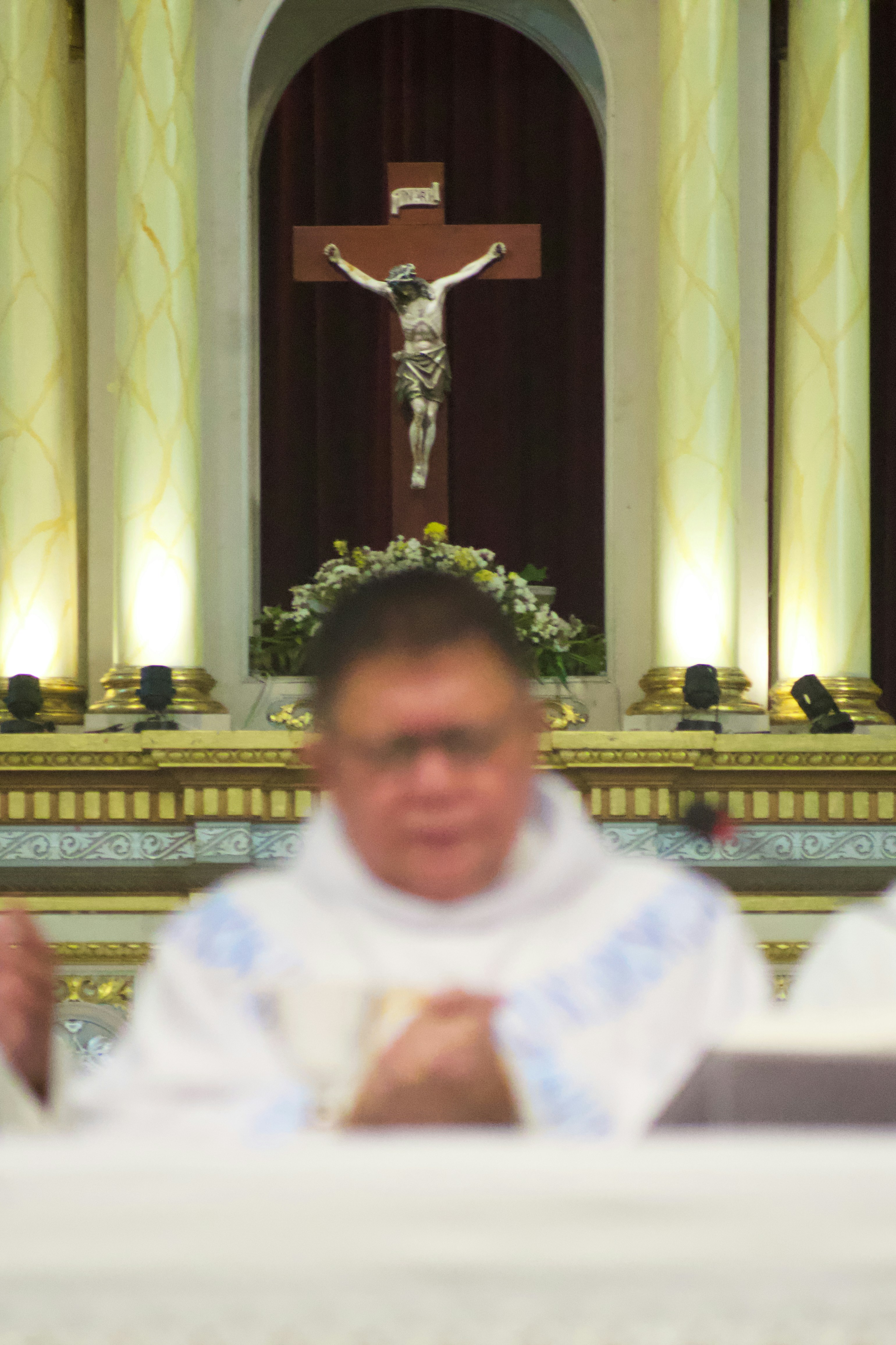 Centered Cross, Quiet Focus: A Blurred Presence at the Altar