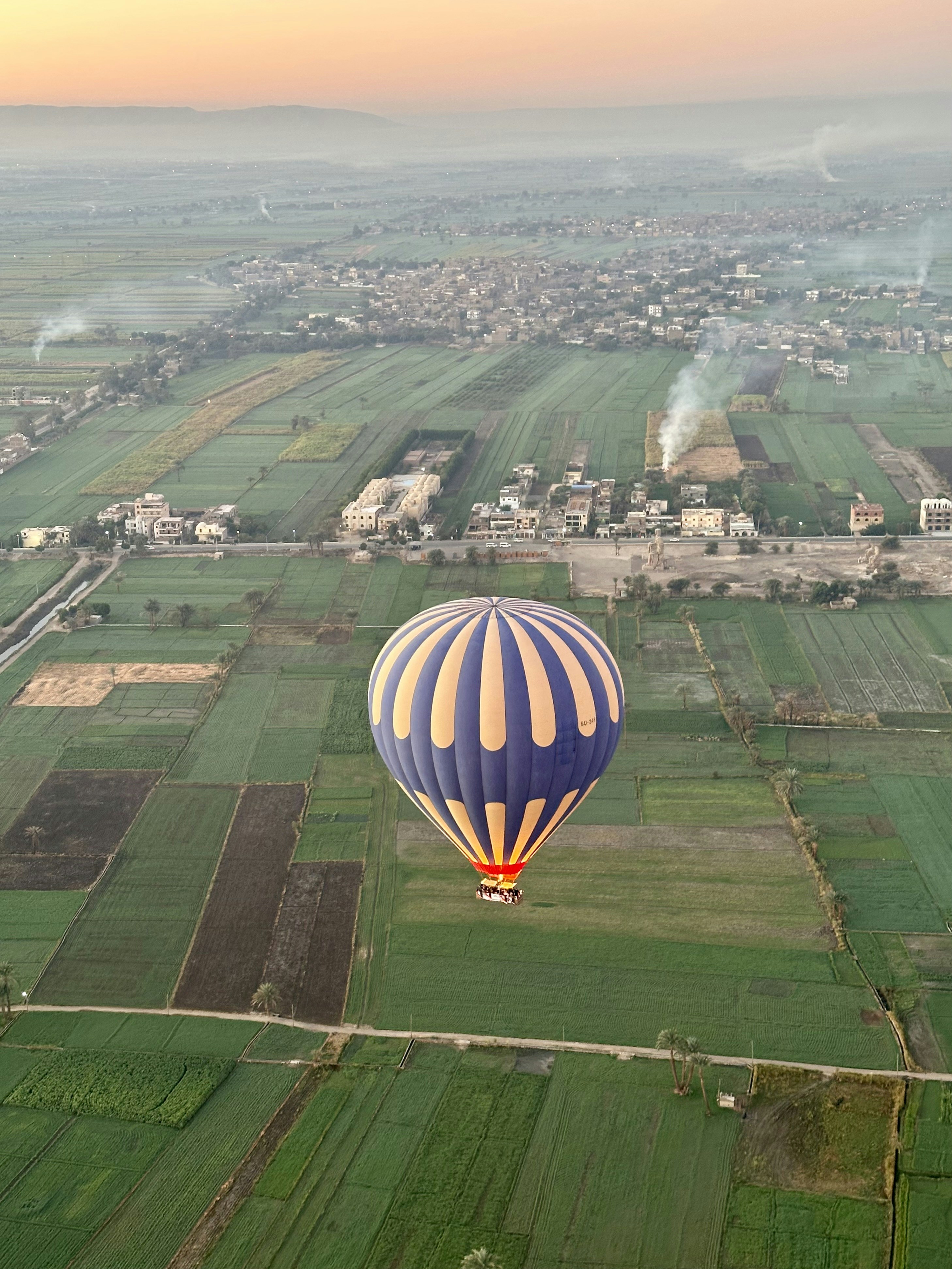 Un globo aerostático volando sobre un exuberante campo verde foto ...