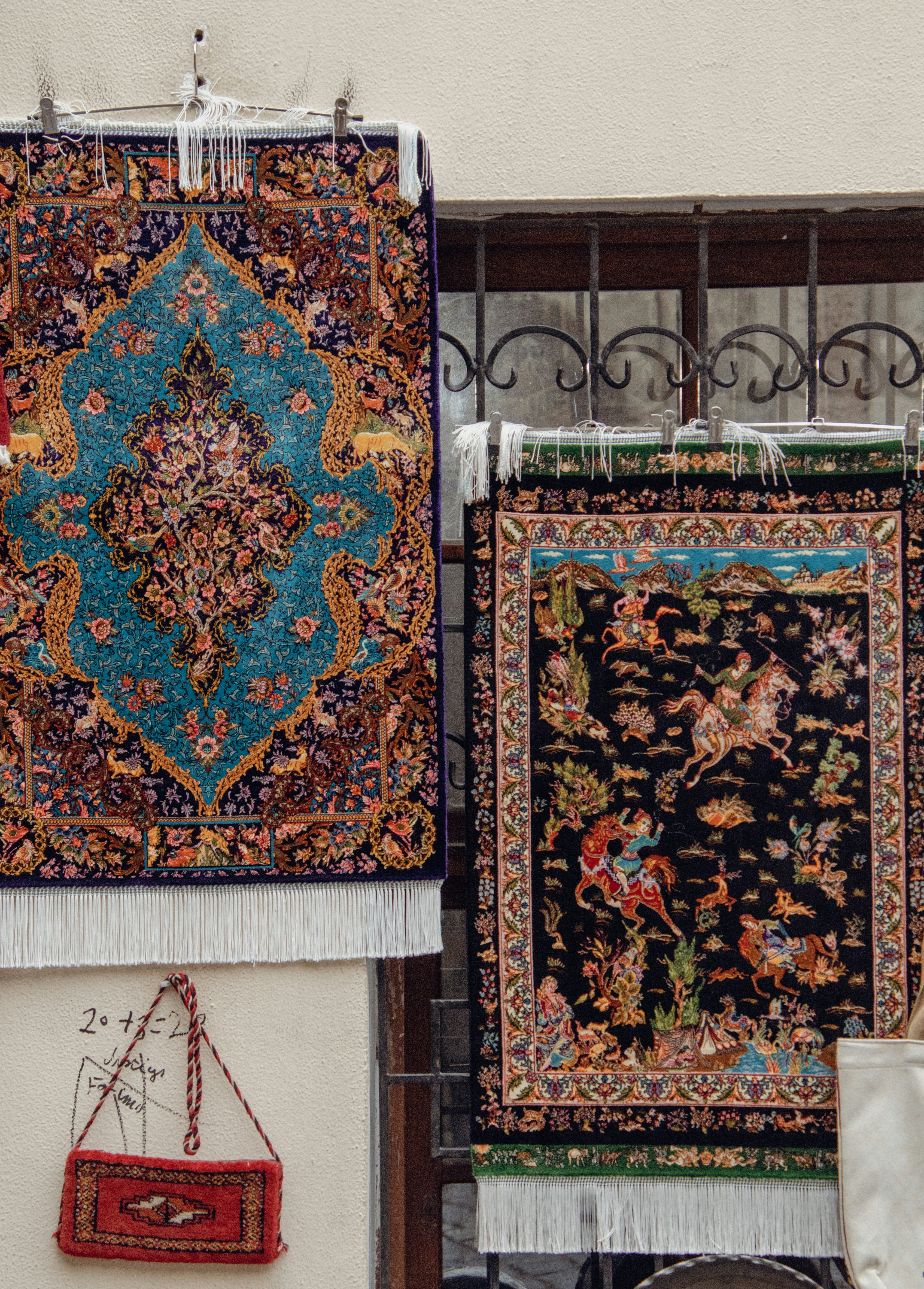 Colorful Persian Rugs Draped Against a Textured Wall