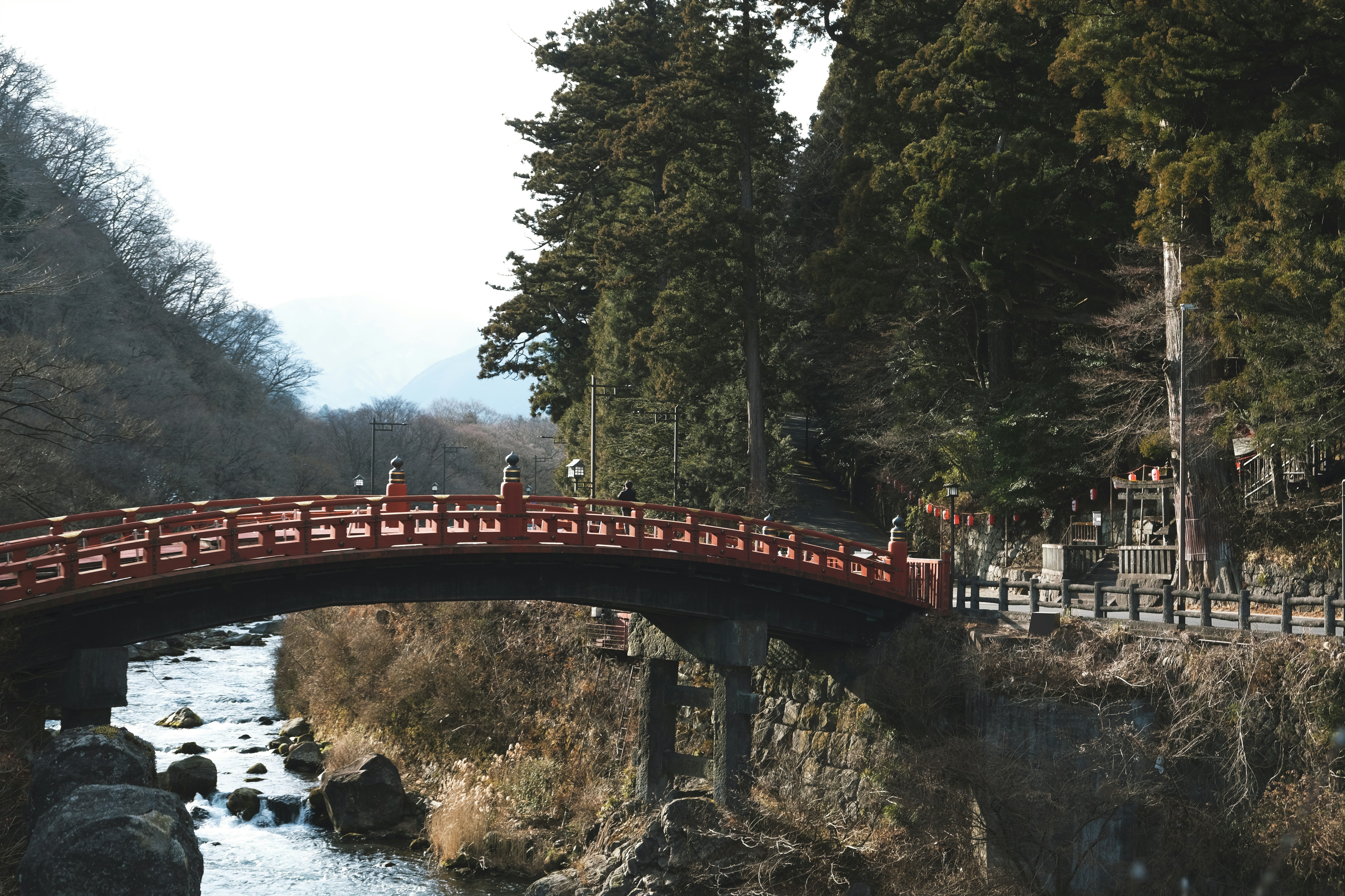 A red bridge over a river with people standing on it photo – Free Tree ...