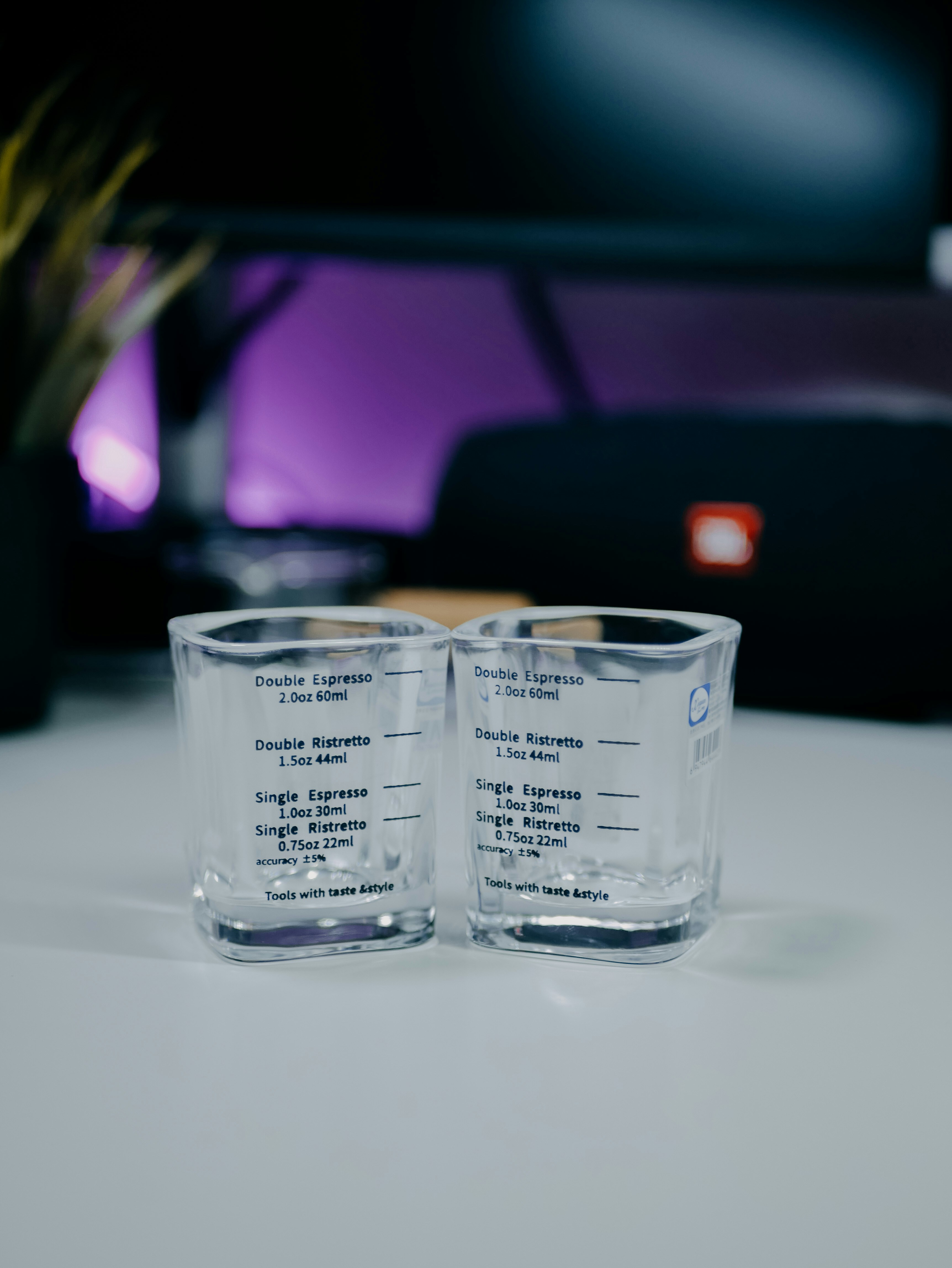 Two Glass Espresso Cups Under Violet Backlight