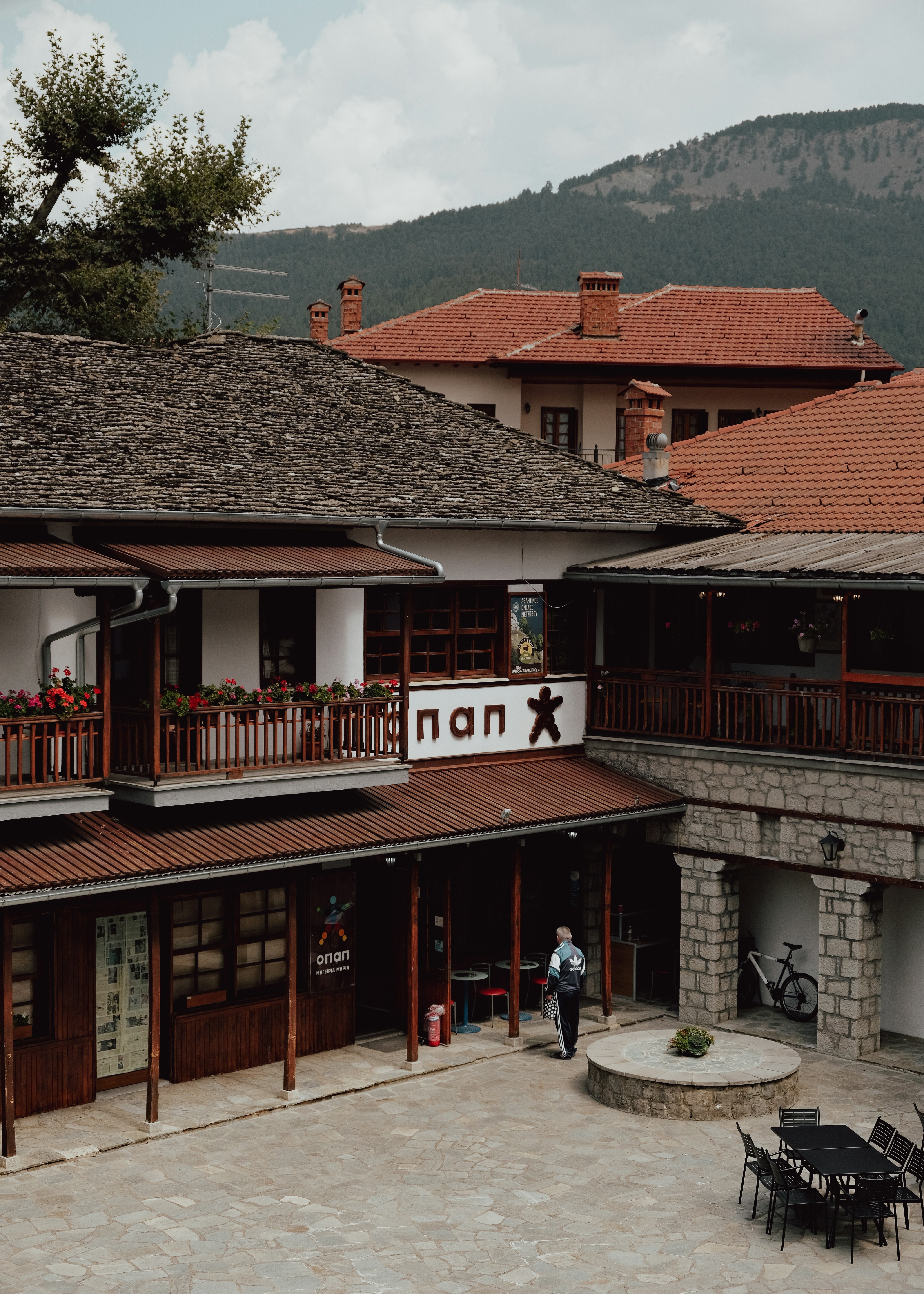 Red-Tiled Courtyard Chronicle: A Cyrillic Sign Amid Mountain Backdrop