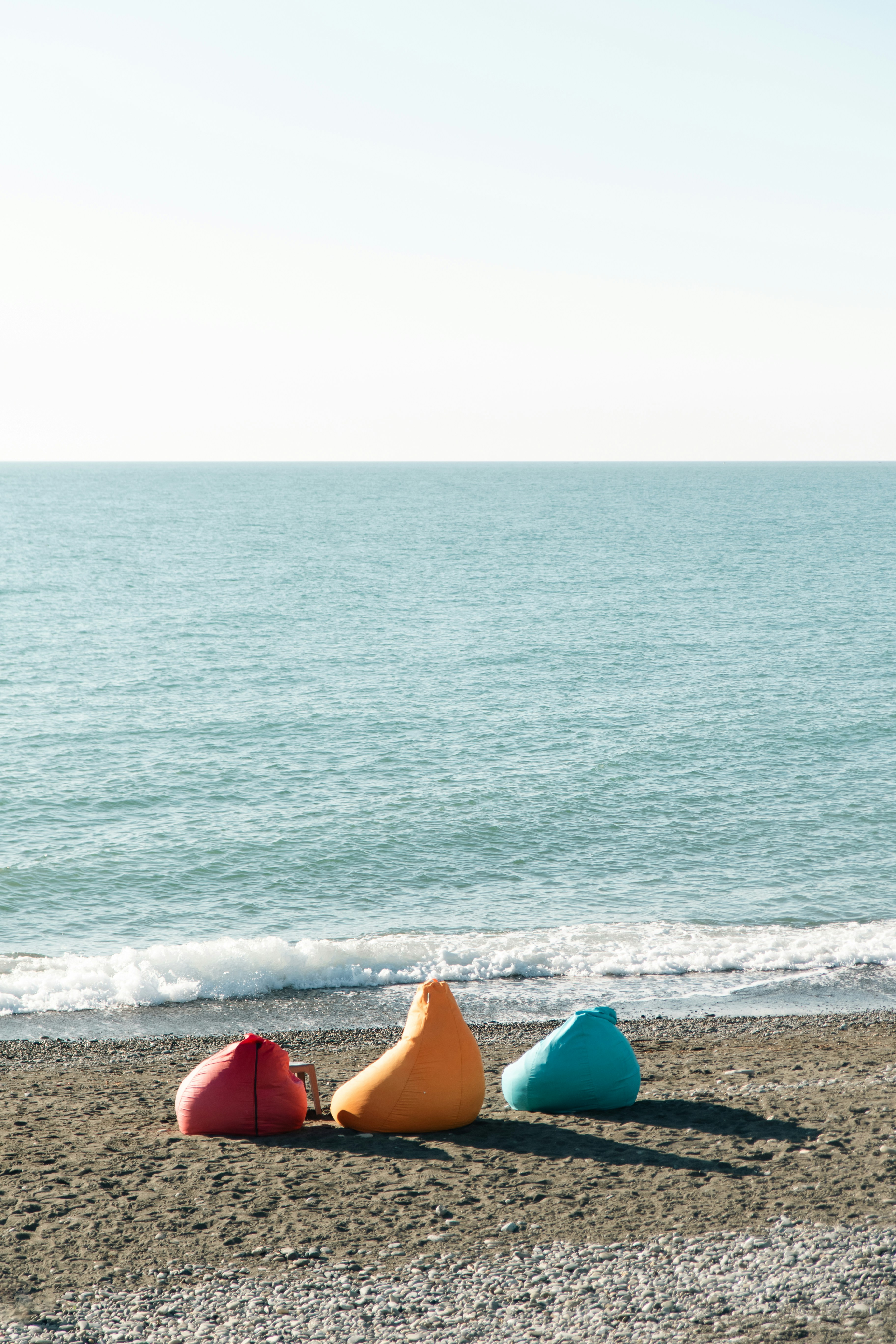 Seaside Trio of Colorful Cushions on a Pebble Beach