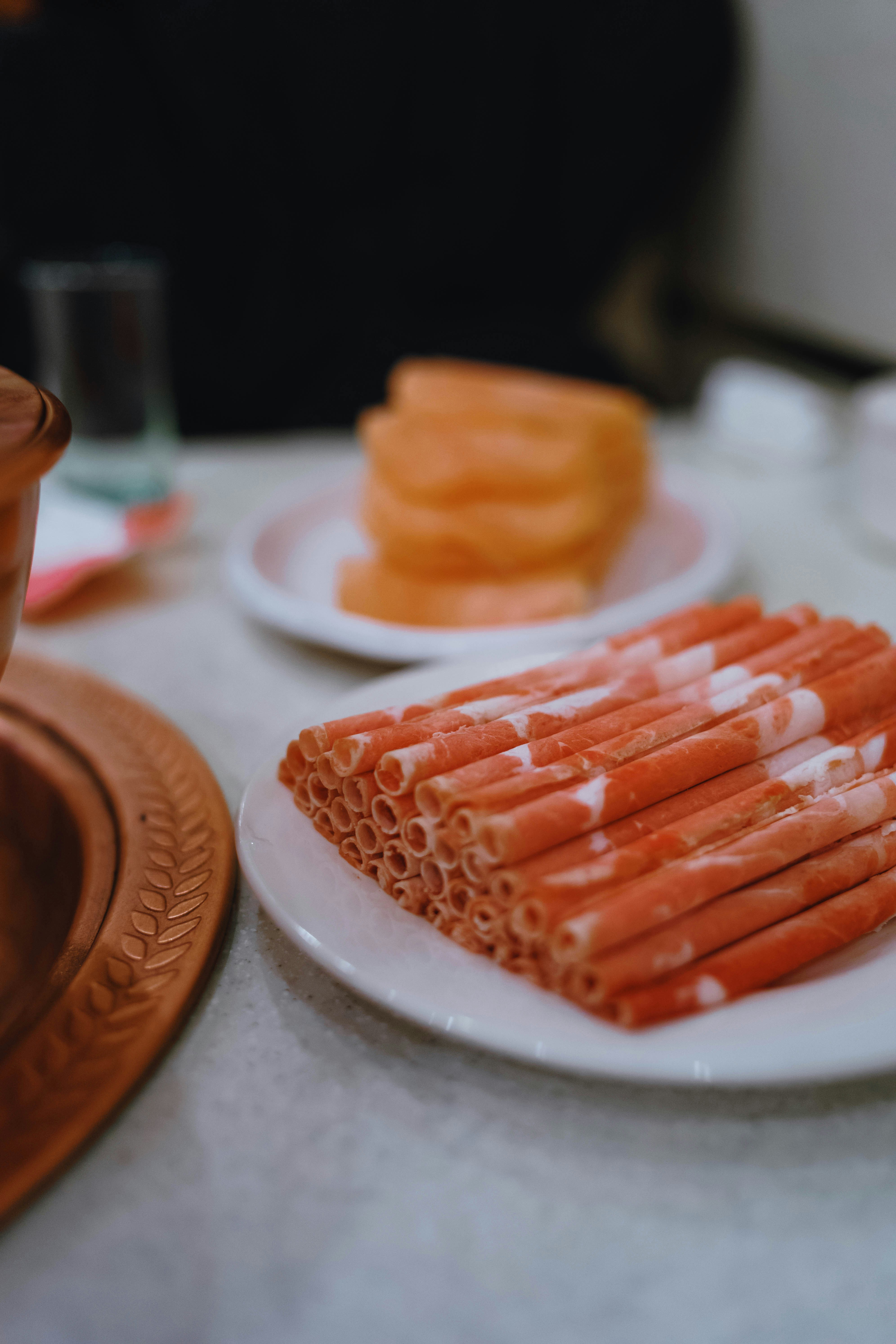 Rows of Pink-and-White Rolled Snacks Anchor a Quiet Table Setting