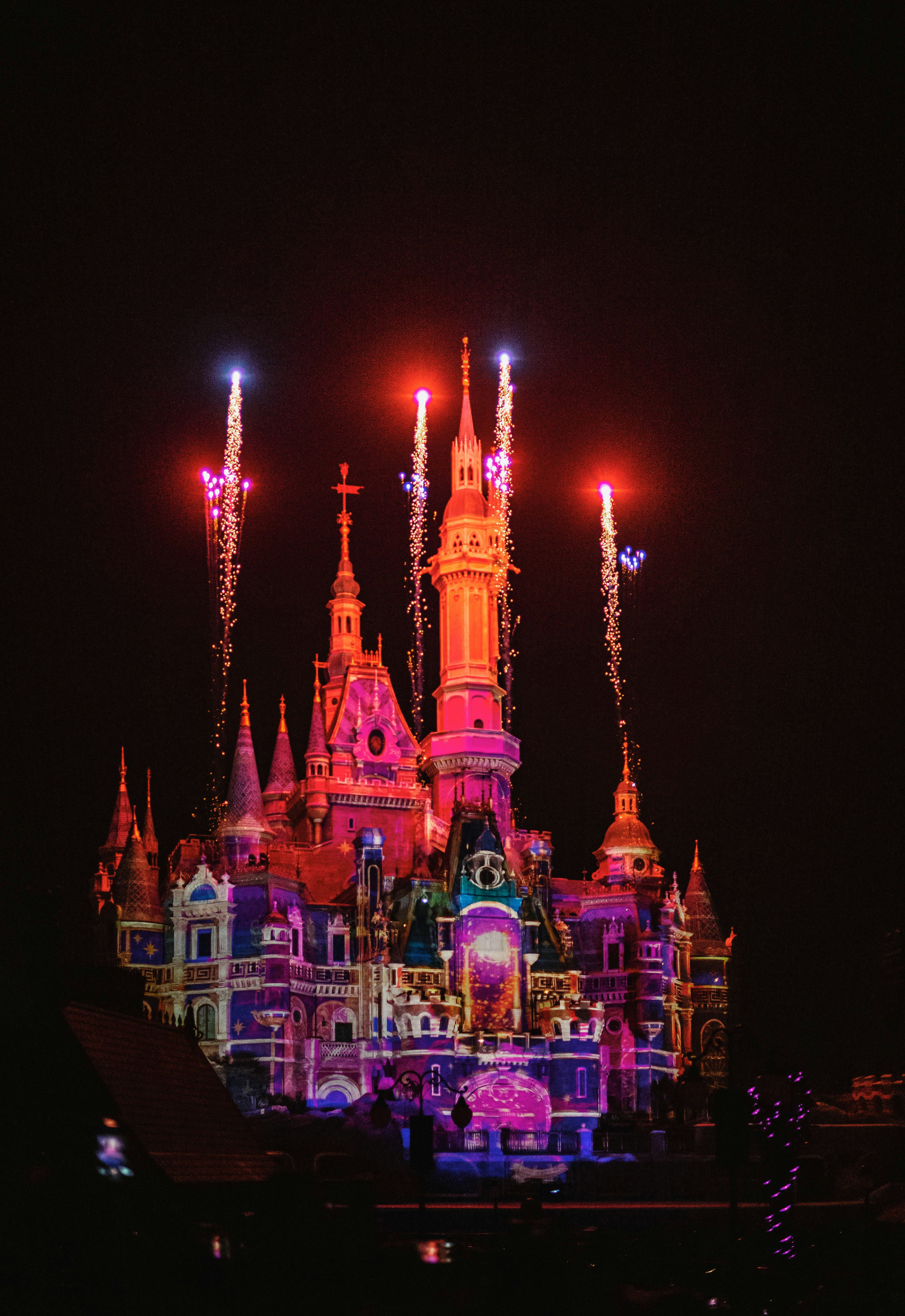 A castle lit up at night with fireworks