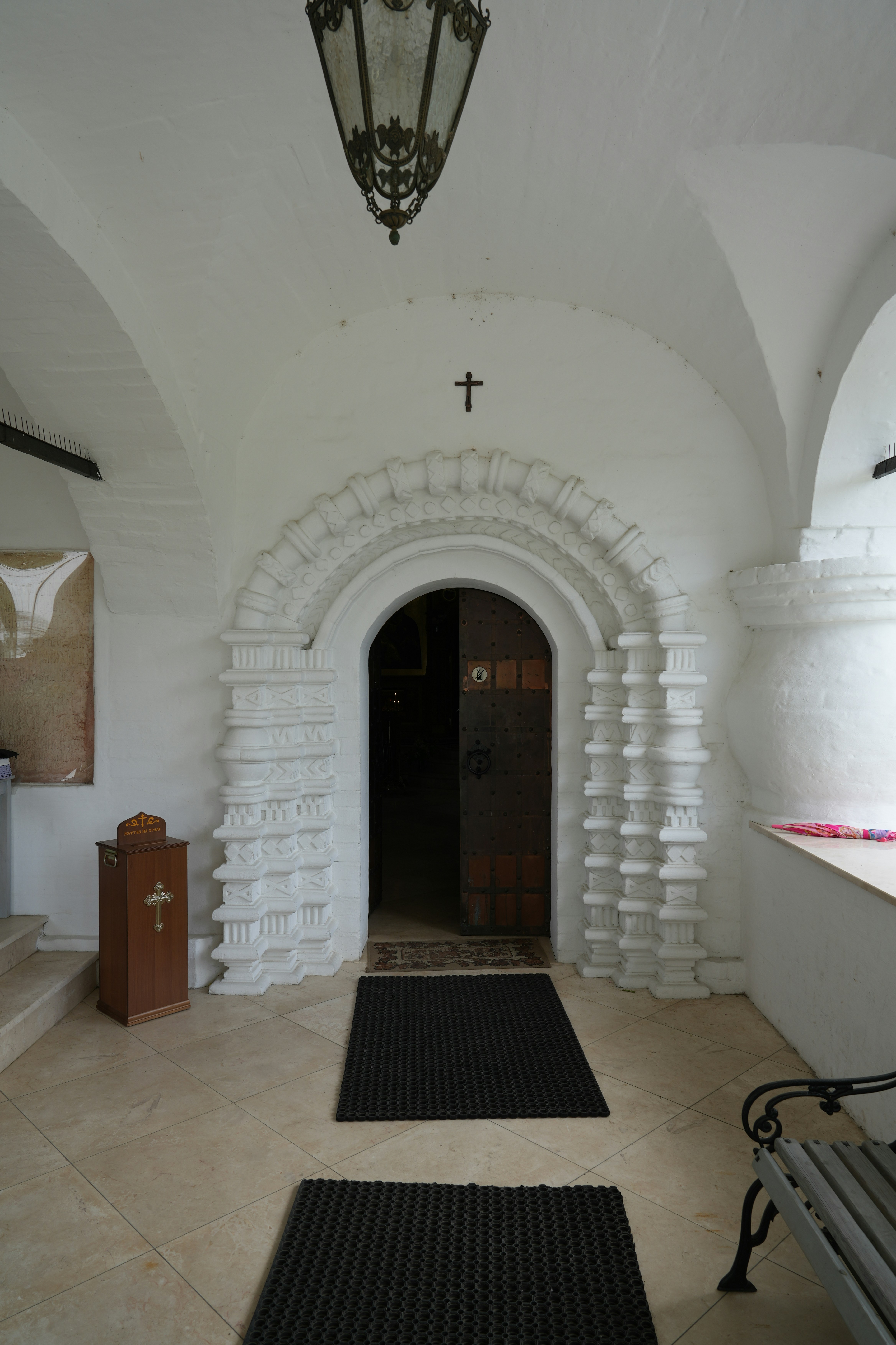 Ivory Archway in a Quiet Chapel: A Carved Gateway Framing the Dim Interior