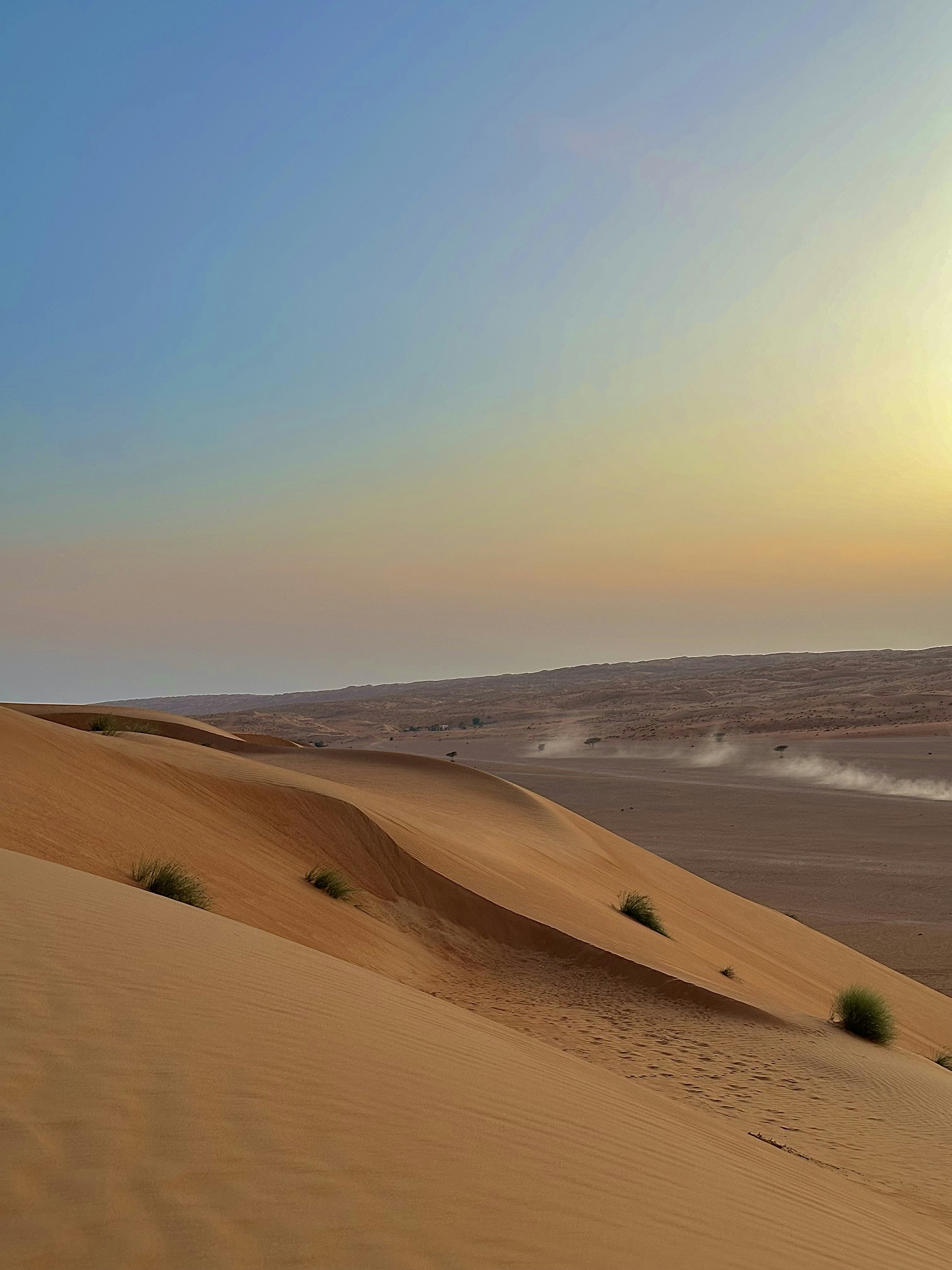The sun is setting over a desert with sand dunes photo – Free Ramlat al ...