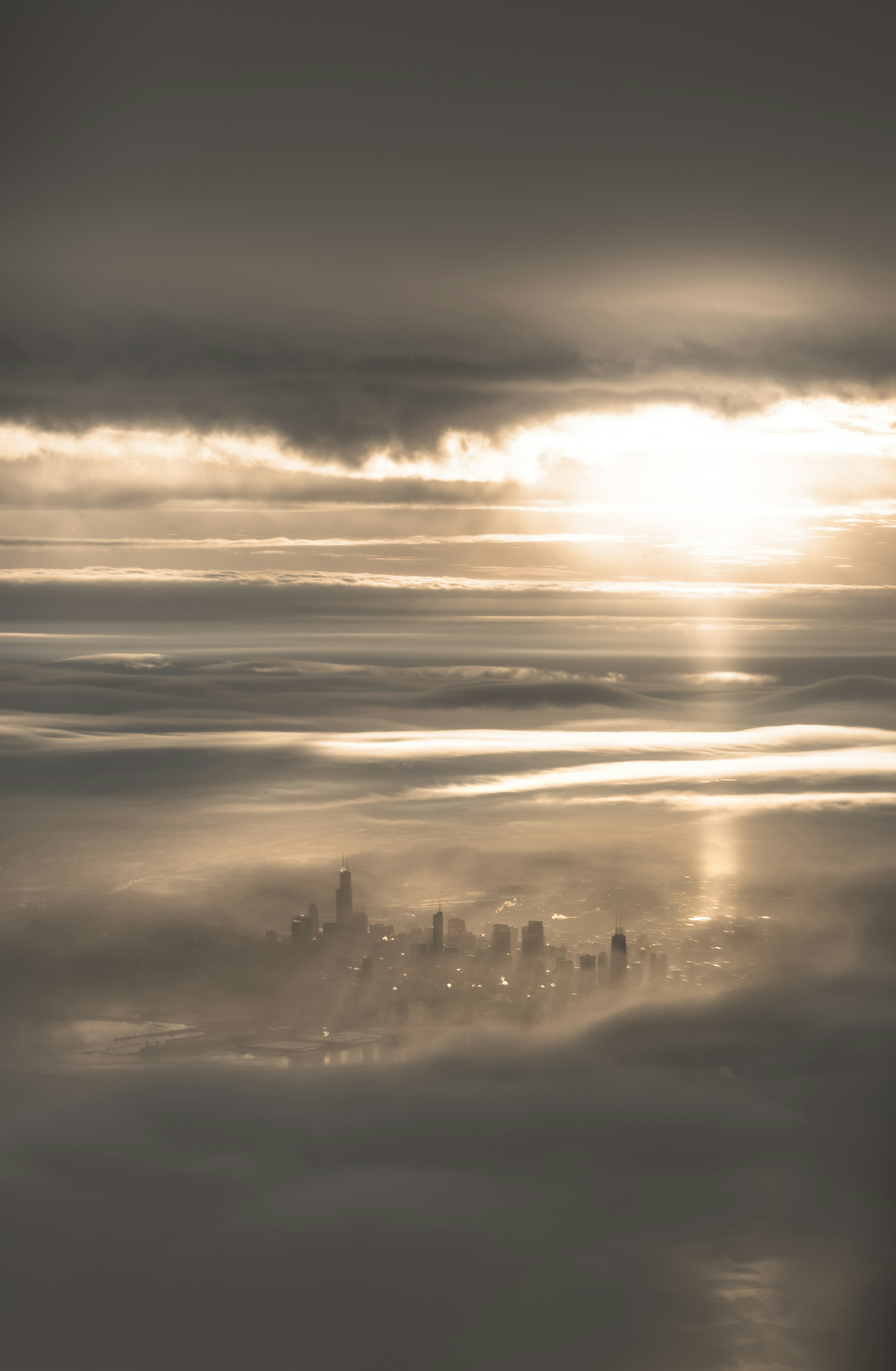 The sun shines through the clouds over a city photo – Free Chicago ...