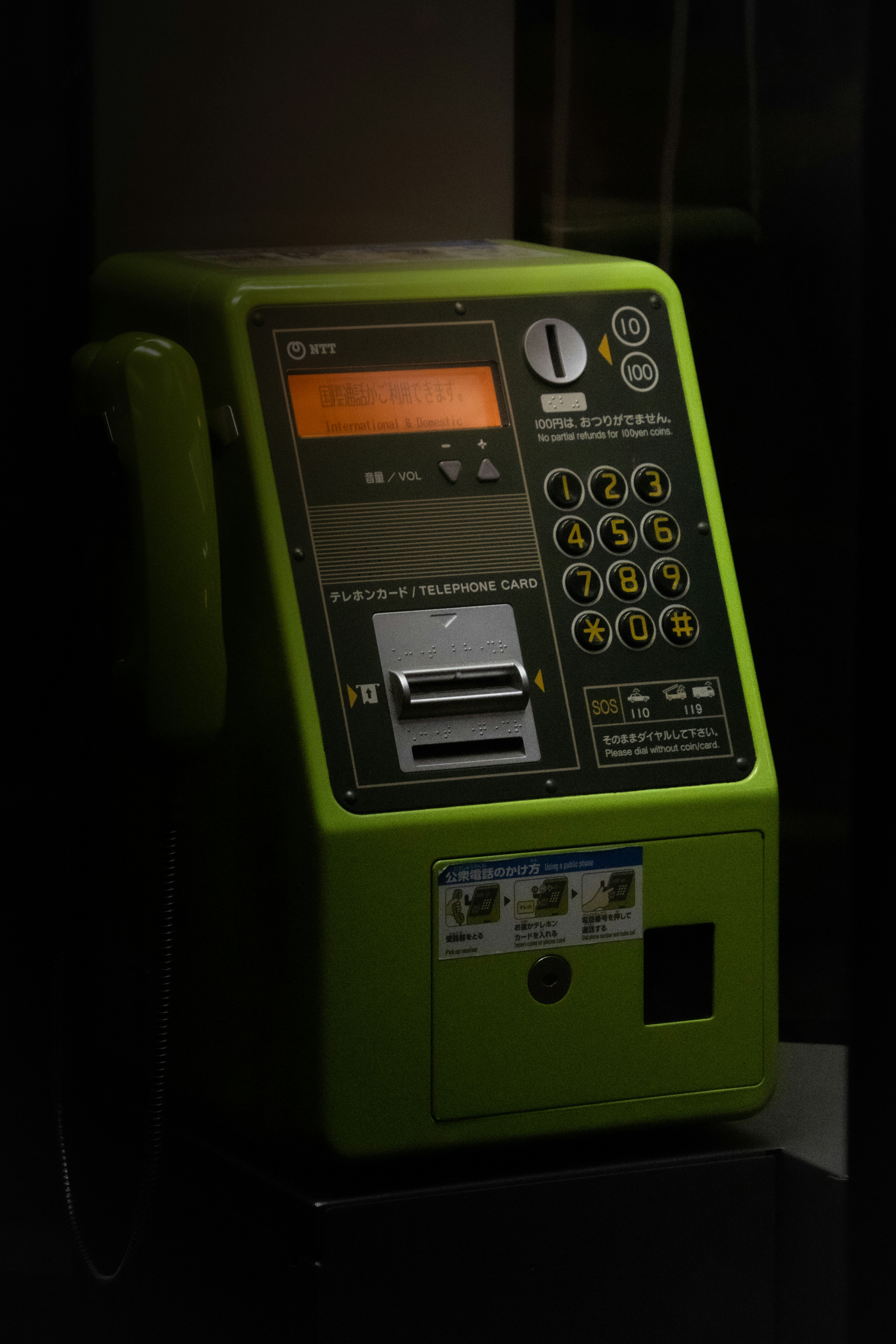 Green Payphone: A Dimly Lit Street Metered in Neon and Silence