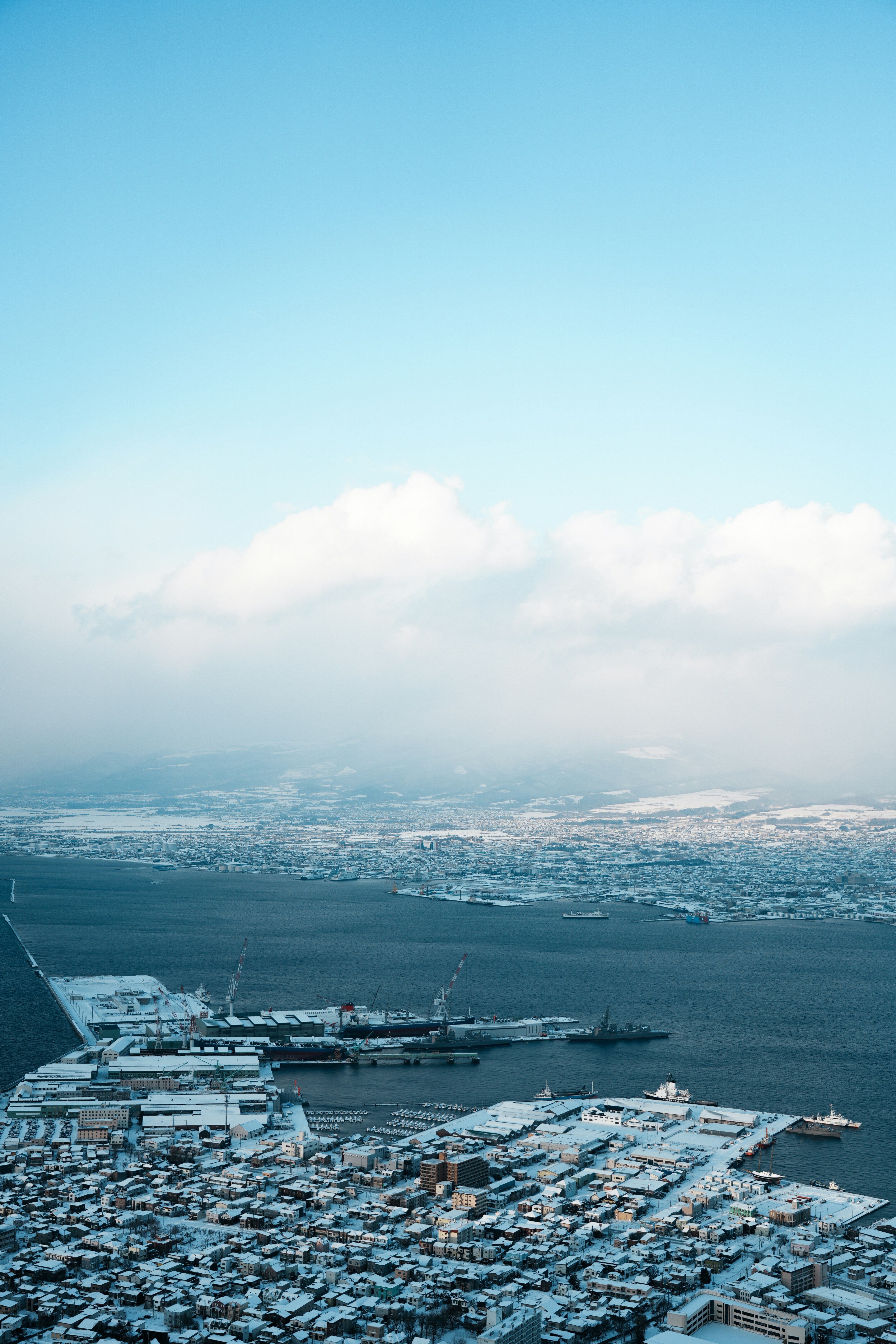 A large body of water surrounded by snow covered buildings