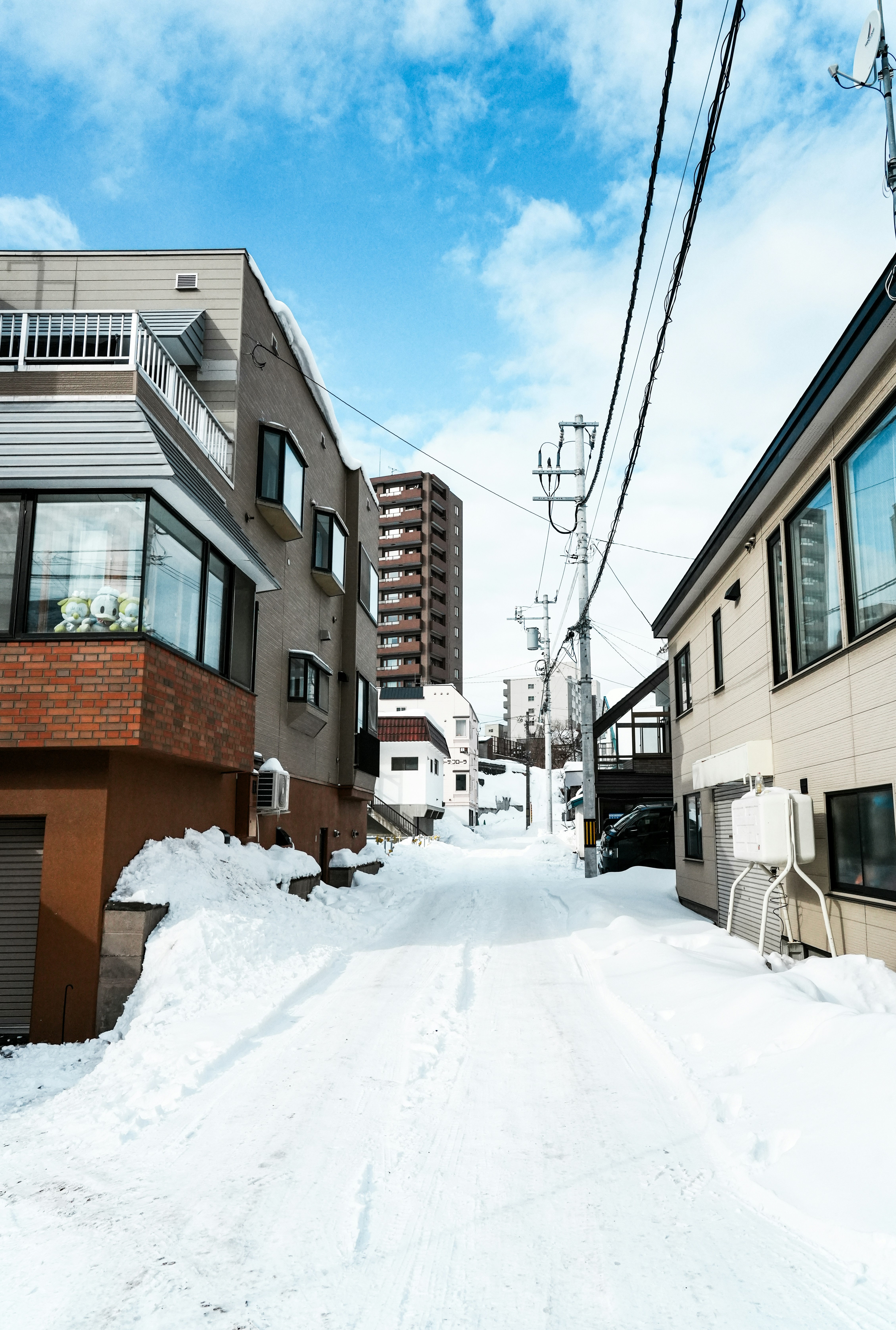 A snow covered street with buildings and a ski lift photo – Free Otaru ...