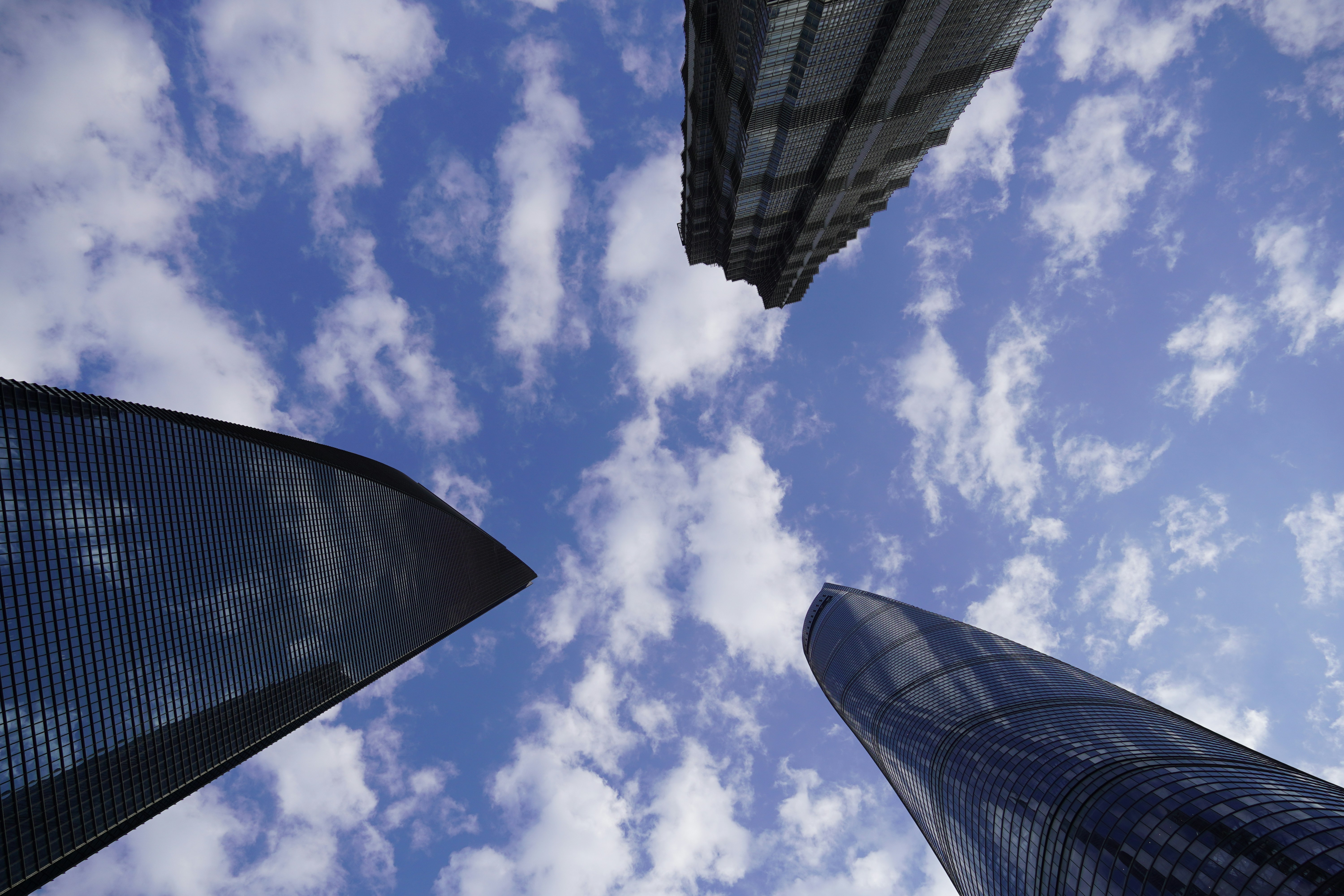 A group of tall buildings under a cloudy blue sky photo – Free Shanghai ...