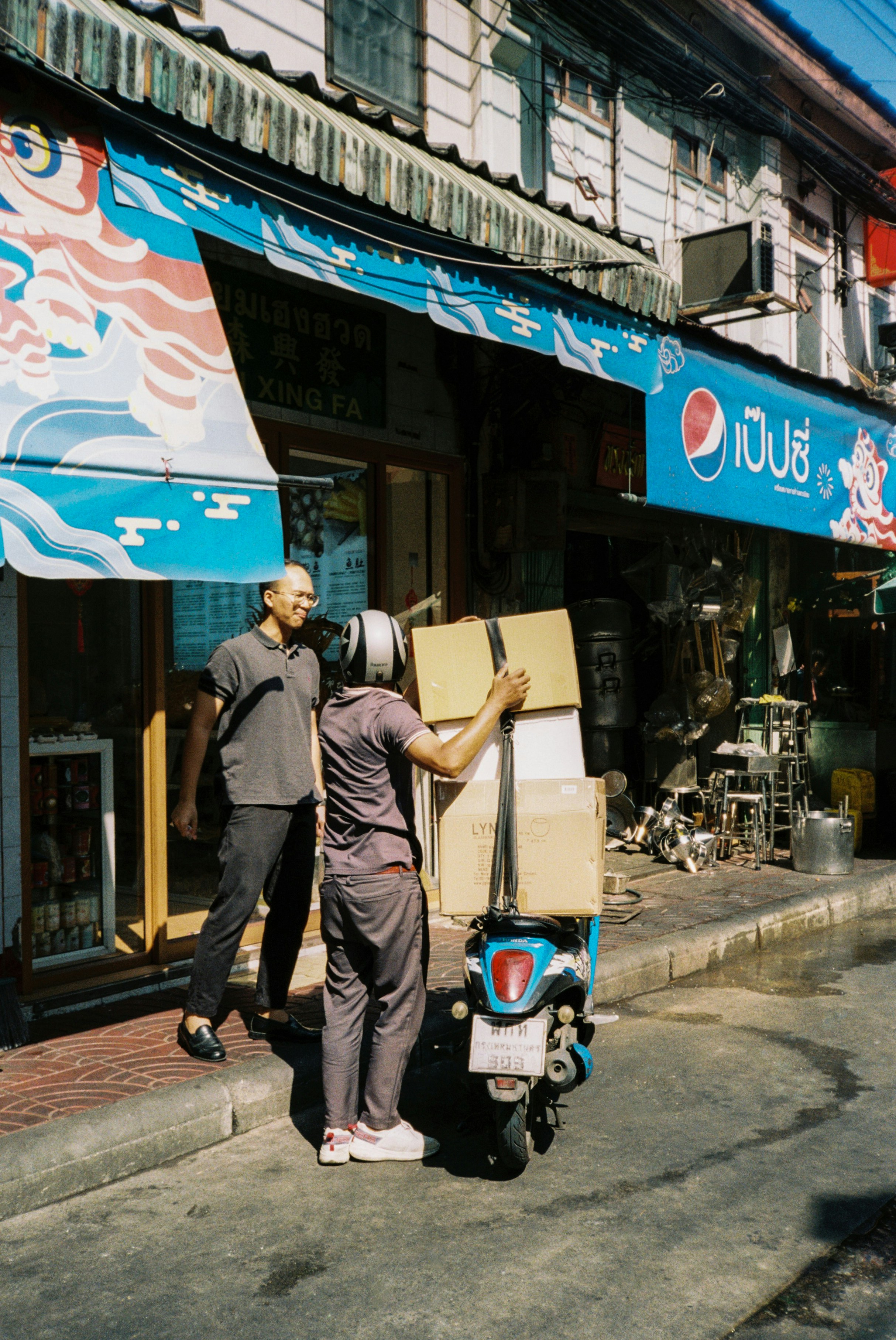 Two men unloading boxes on the back of a moped photo – Free Woman Image ...