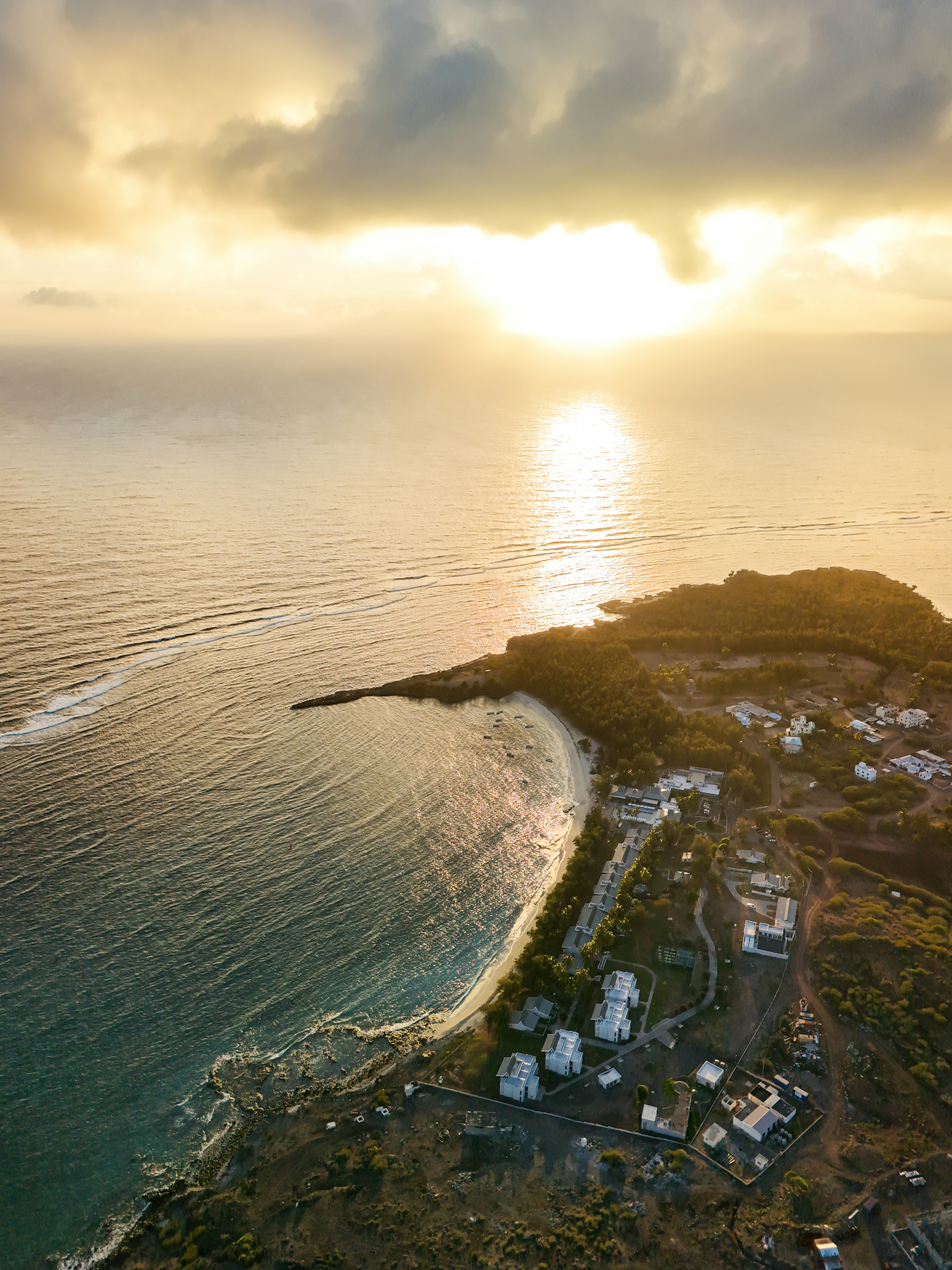 Sunlit Crest: A Drone View of a Cliffside Coastal Village at Sunset