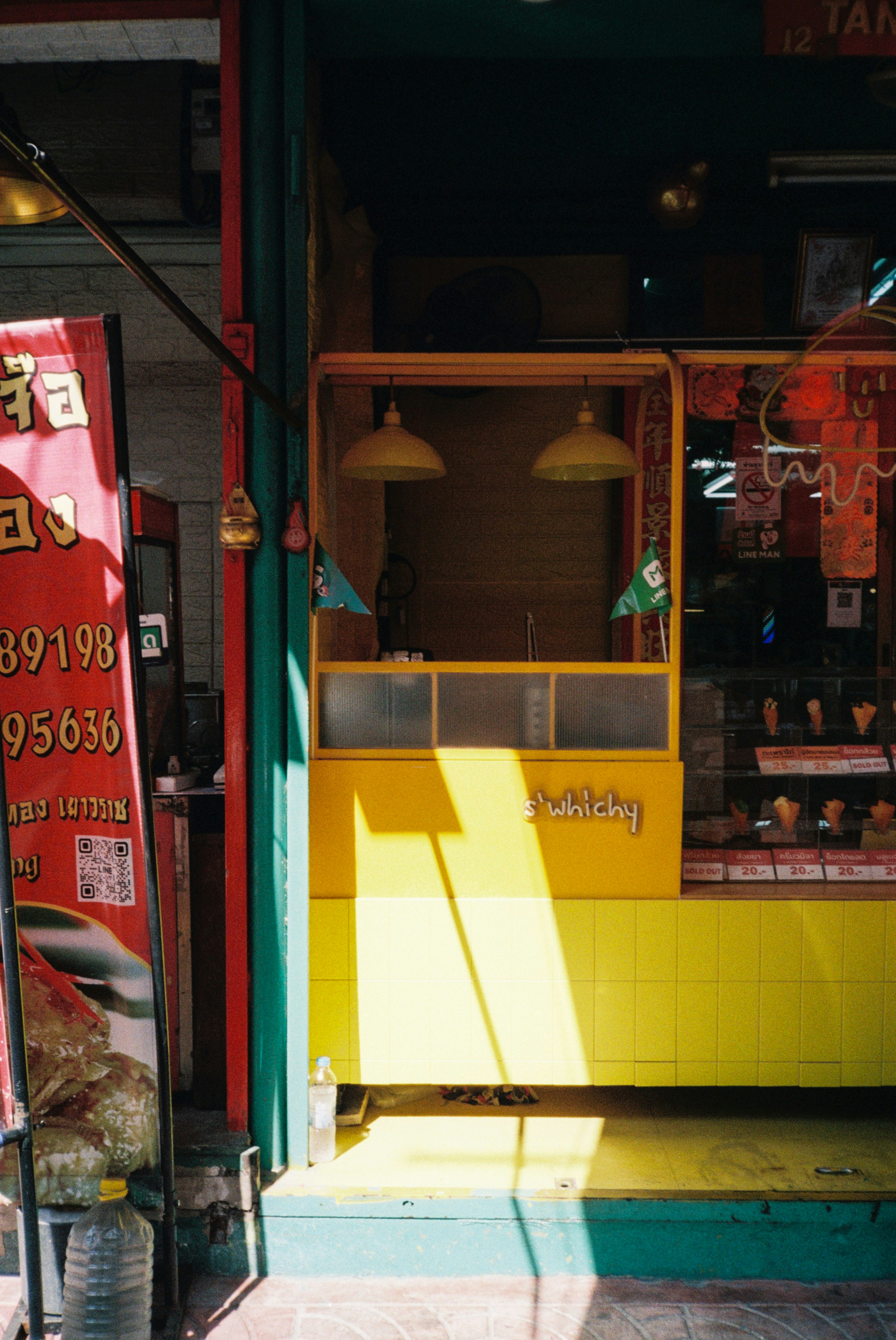 A yellow and red food stand sitting in front of a building photo – Free ...