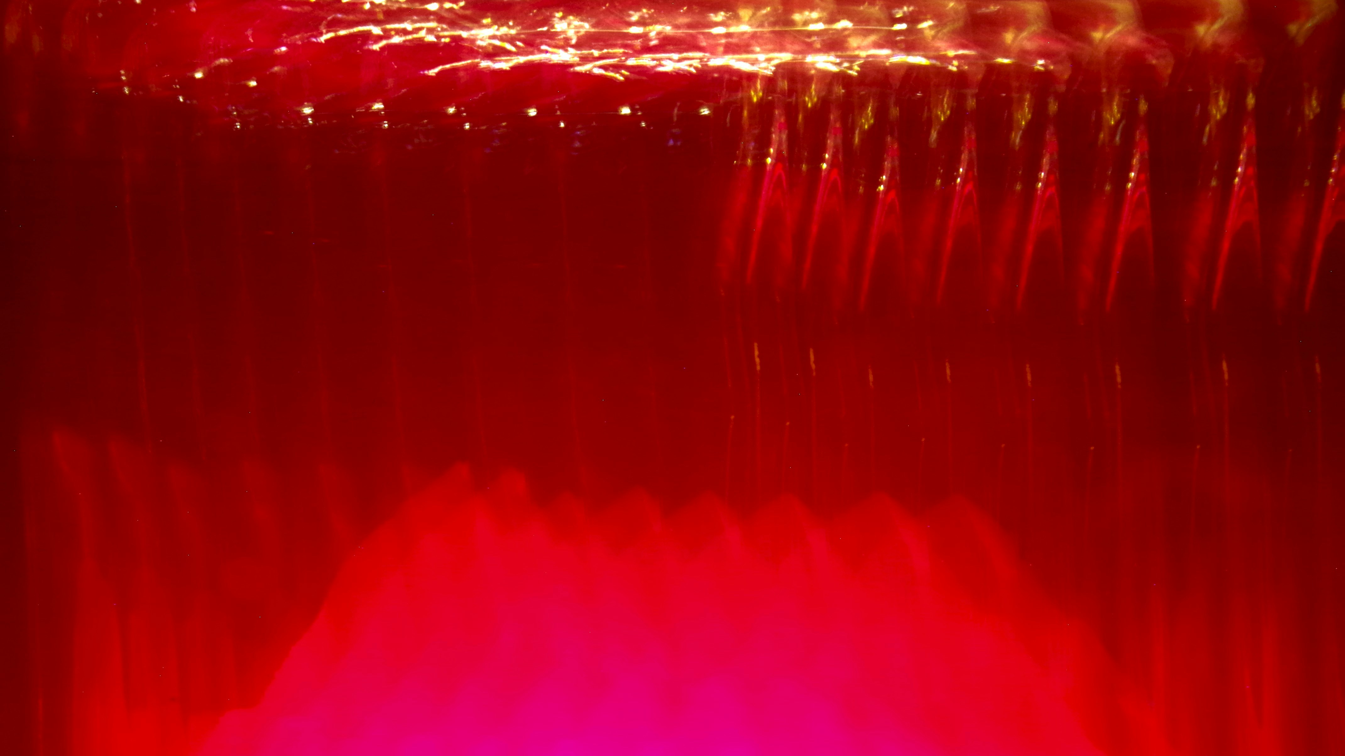 Abstract pattern of red and pink hues created with light and tissue paper.