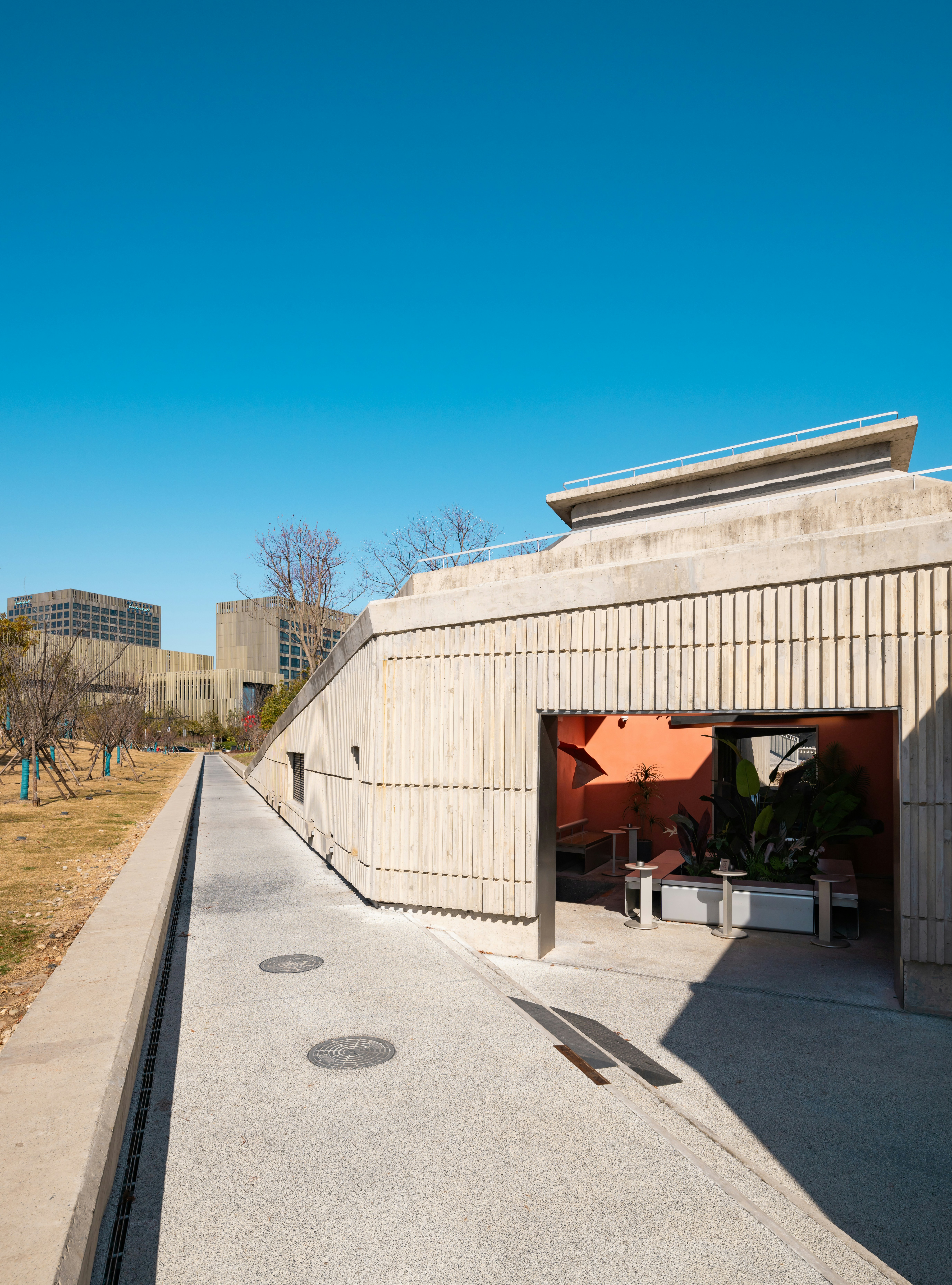 Blue Skies Over Concrete Angles: Path to an Orange Interior