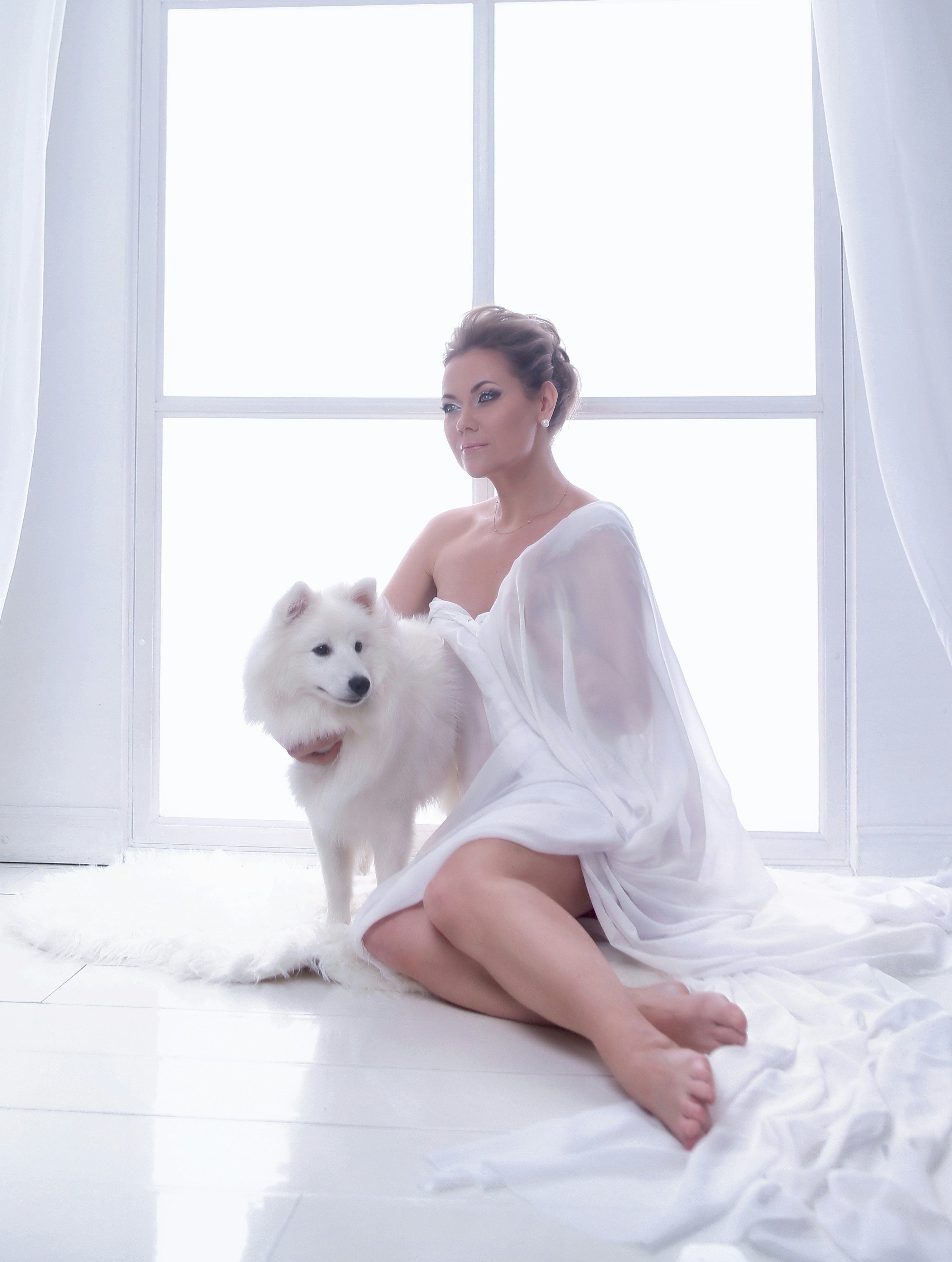 Snowlit Studio Portrait: Woman and White Samoyed by a Backlit Window