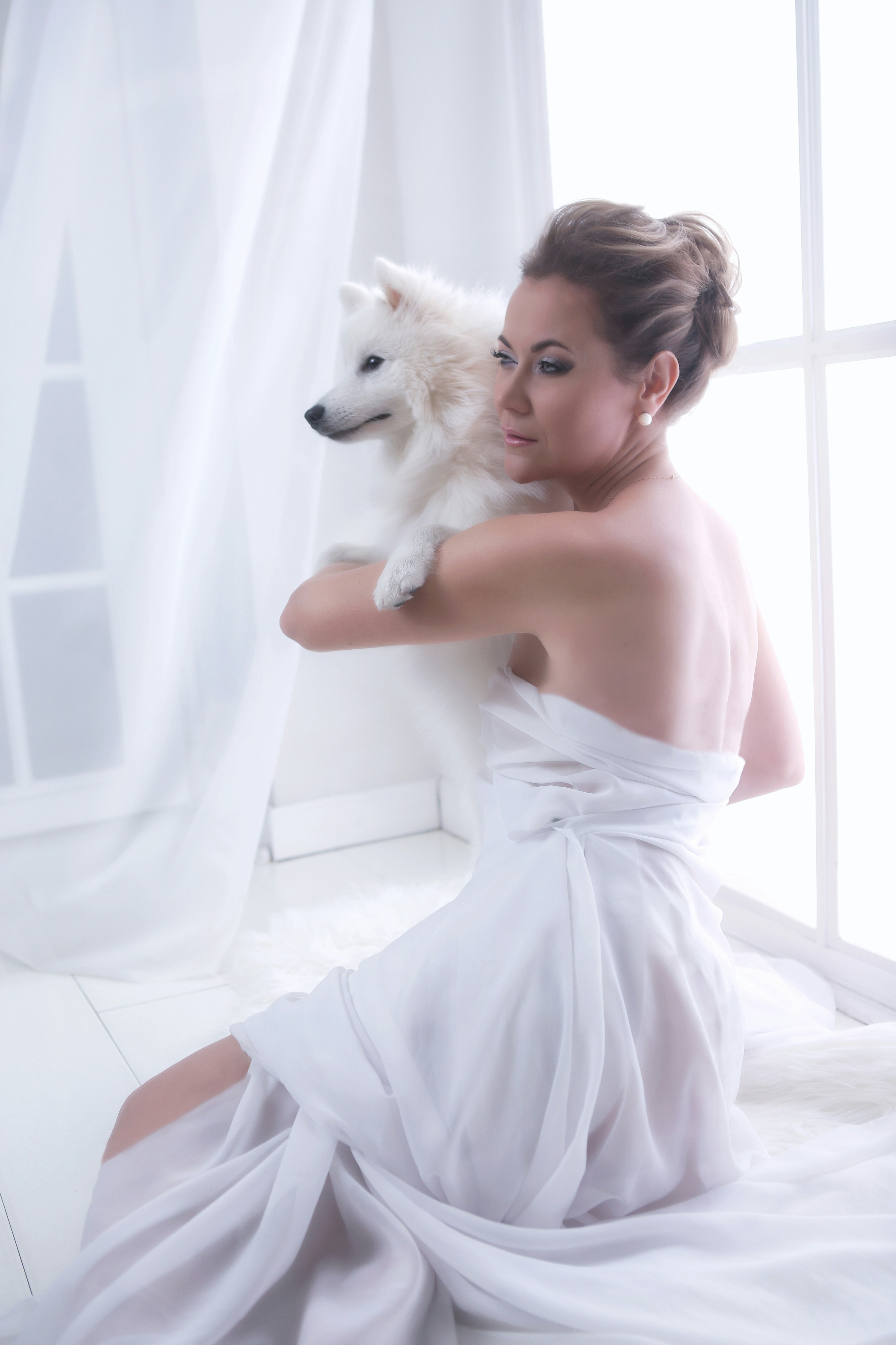 Luminous Quiet: A Woman and Her White Spitz by a Sunlit Window