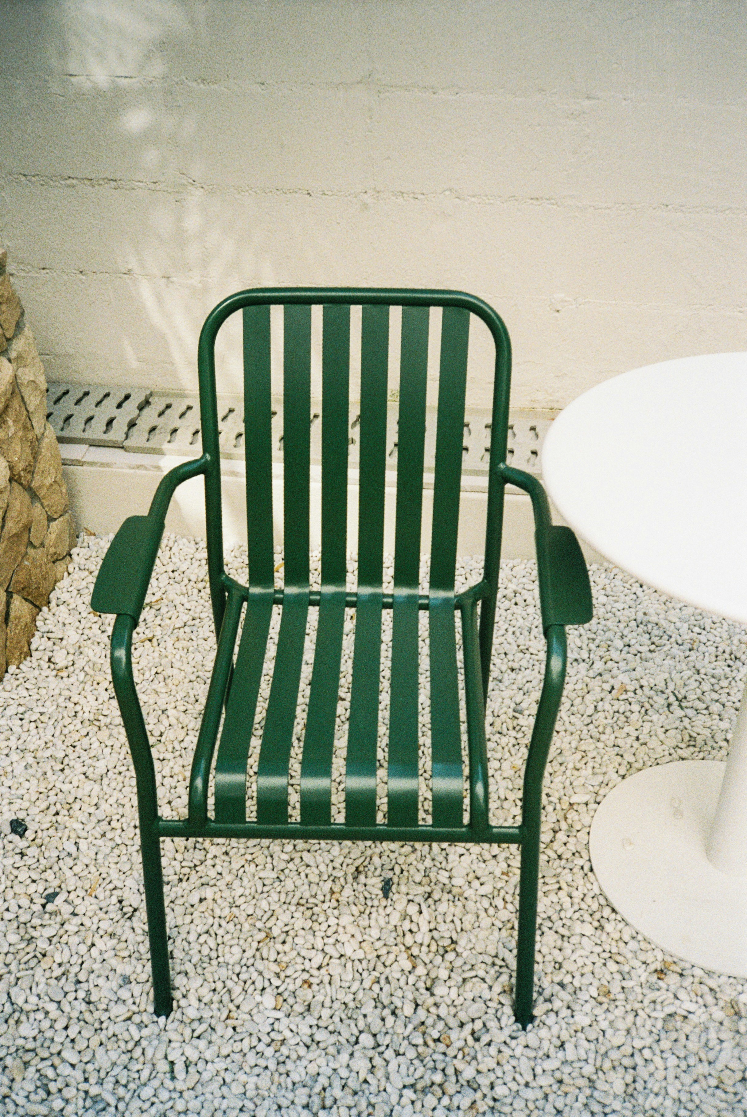 Verdant Steel Chair on Pebble Terrace by a White Round Table