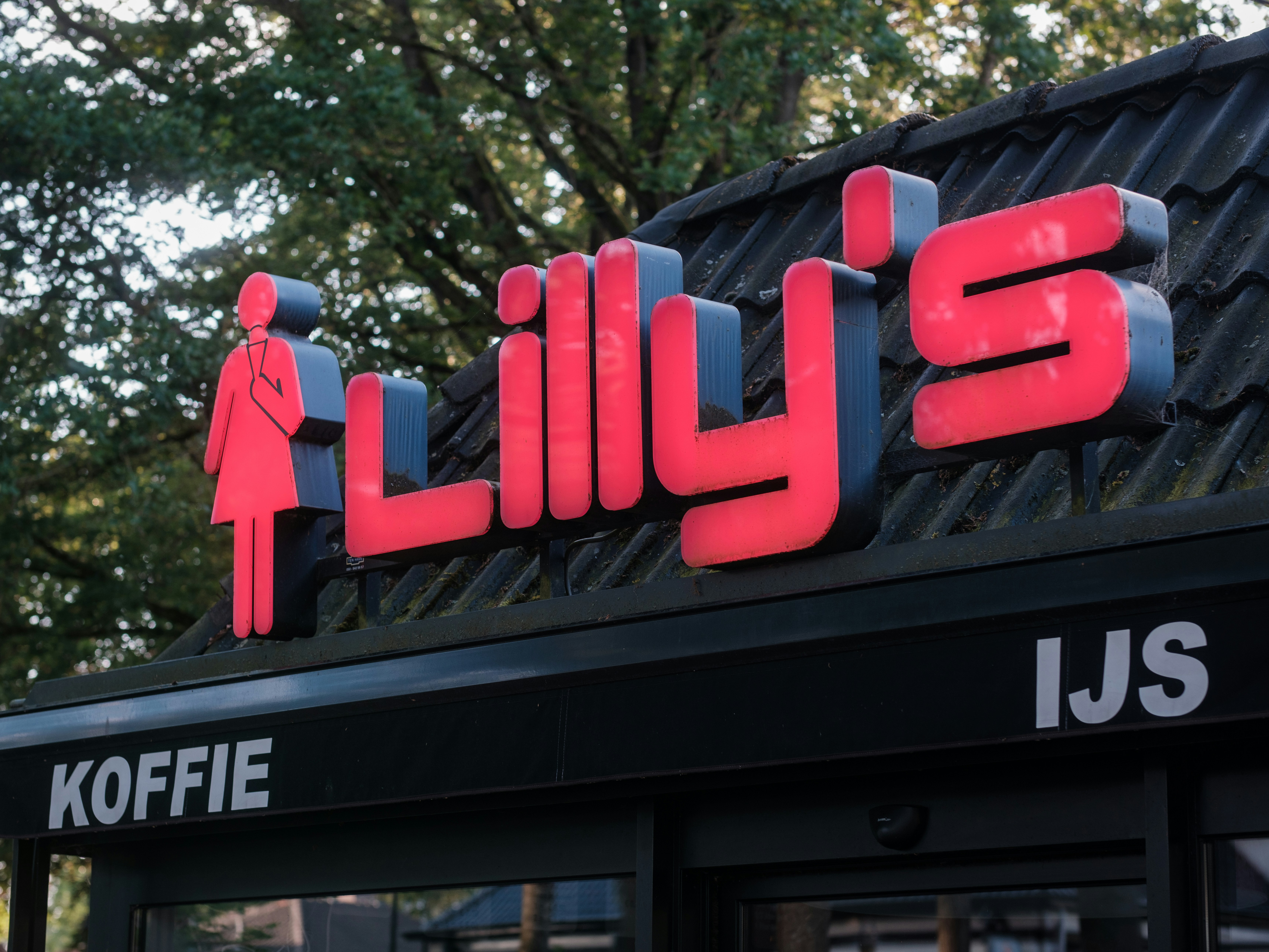 A large neon sign on the side of a building photo – Free Sign Image on ...