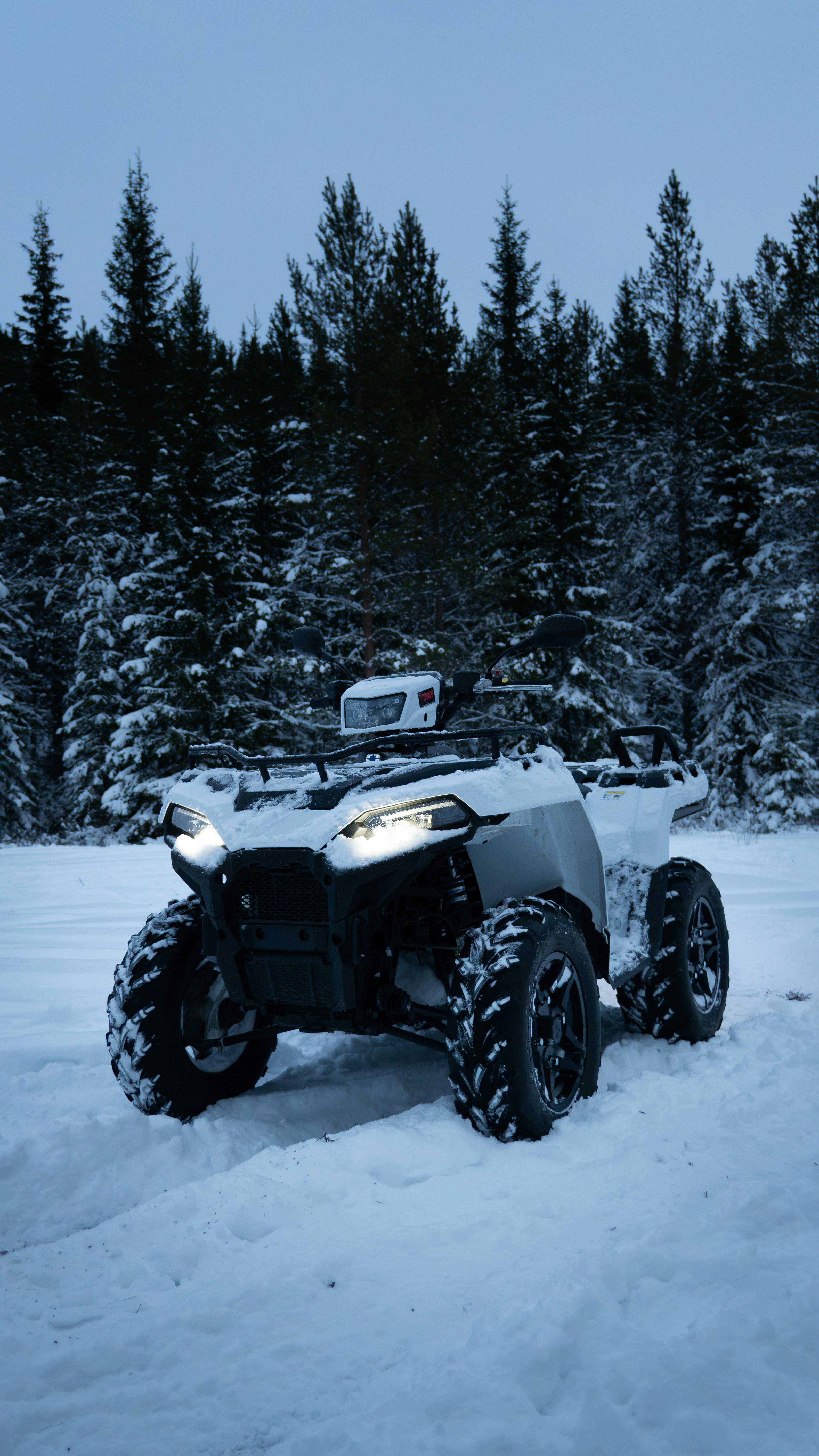 A white four - wheeler is parked in the snow photo – Free Winter Image ...