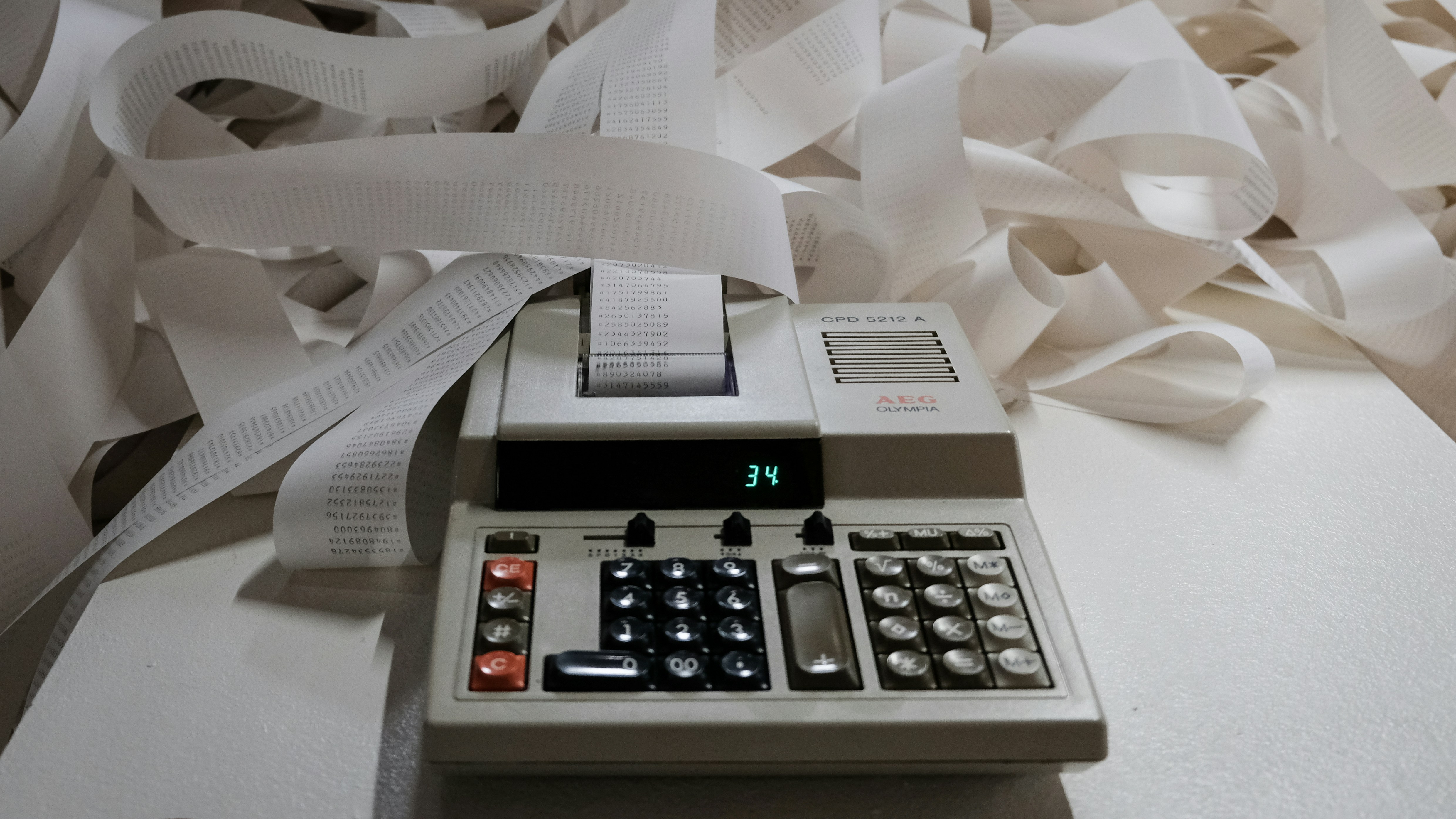 A calculator sitting on top of a white table photo – Free Calculator ...