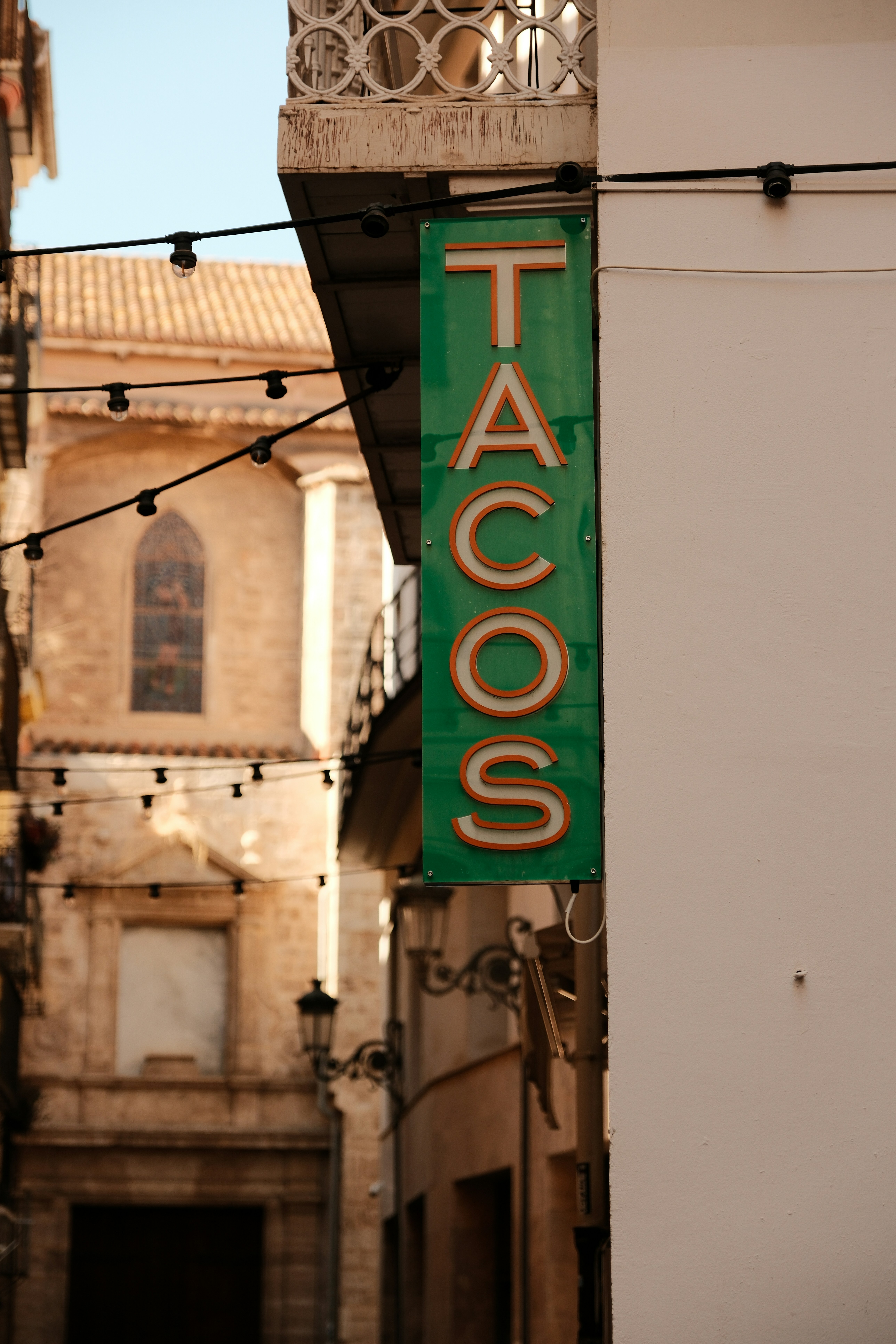 A taco sign hanging from the side of a building photo – Free Tacos ...