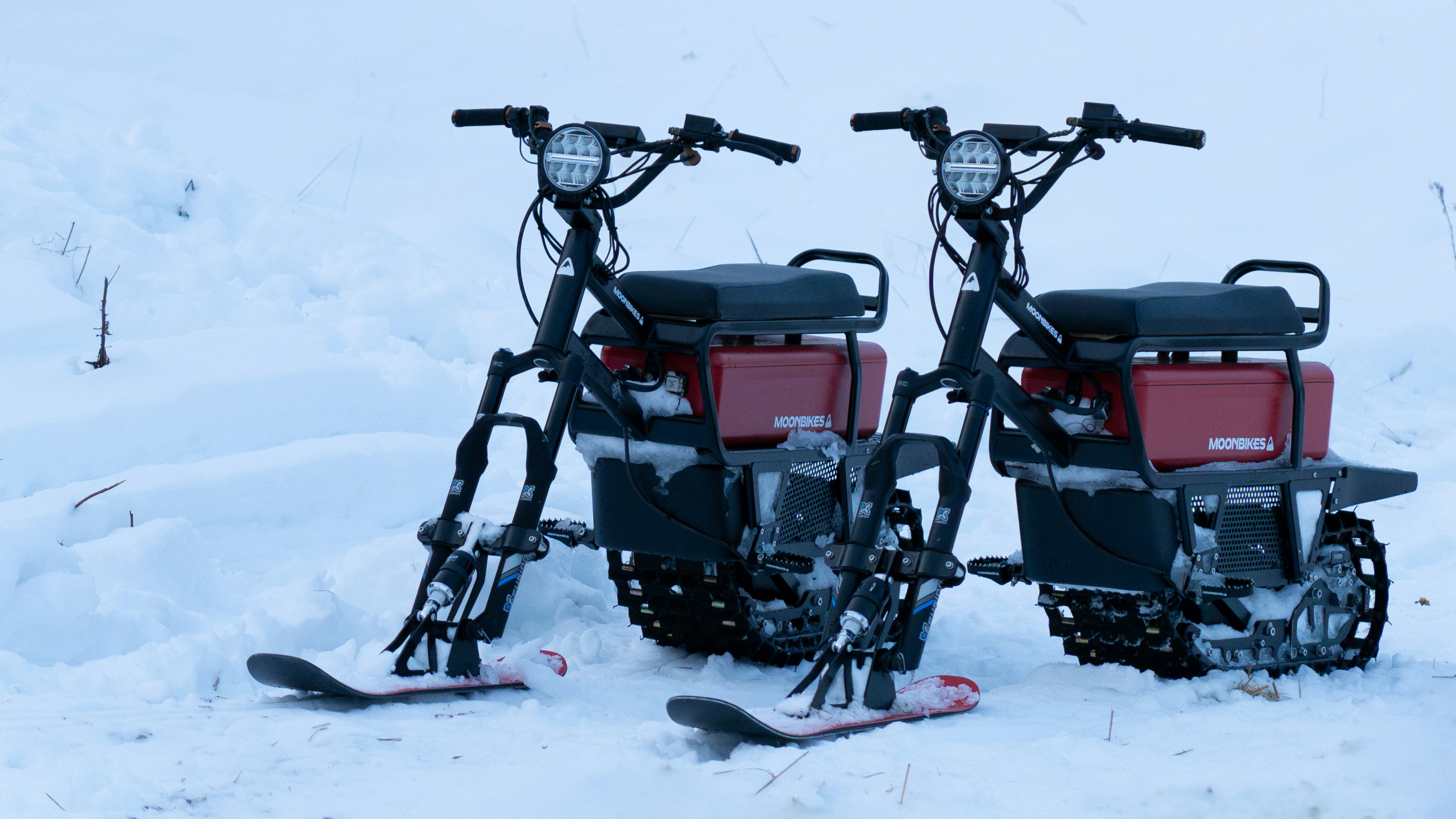 Twin Snow Machines Resting in Quiet Snowfield