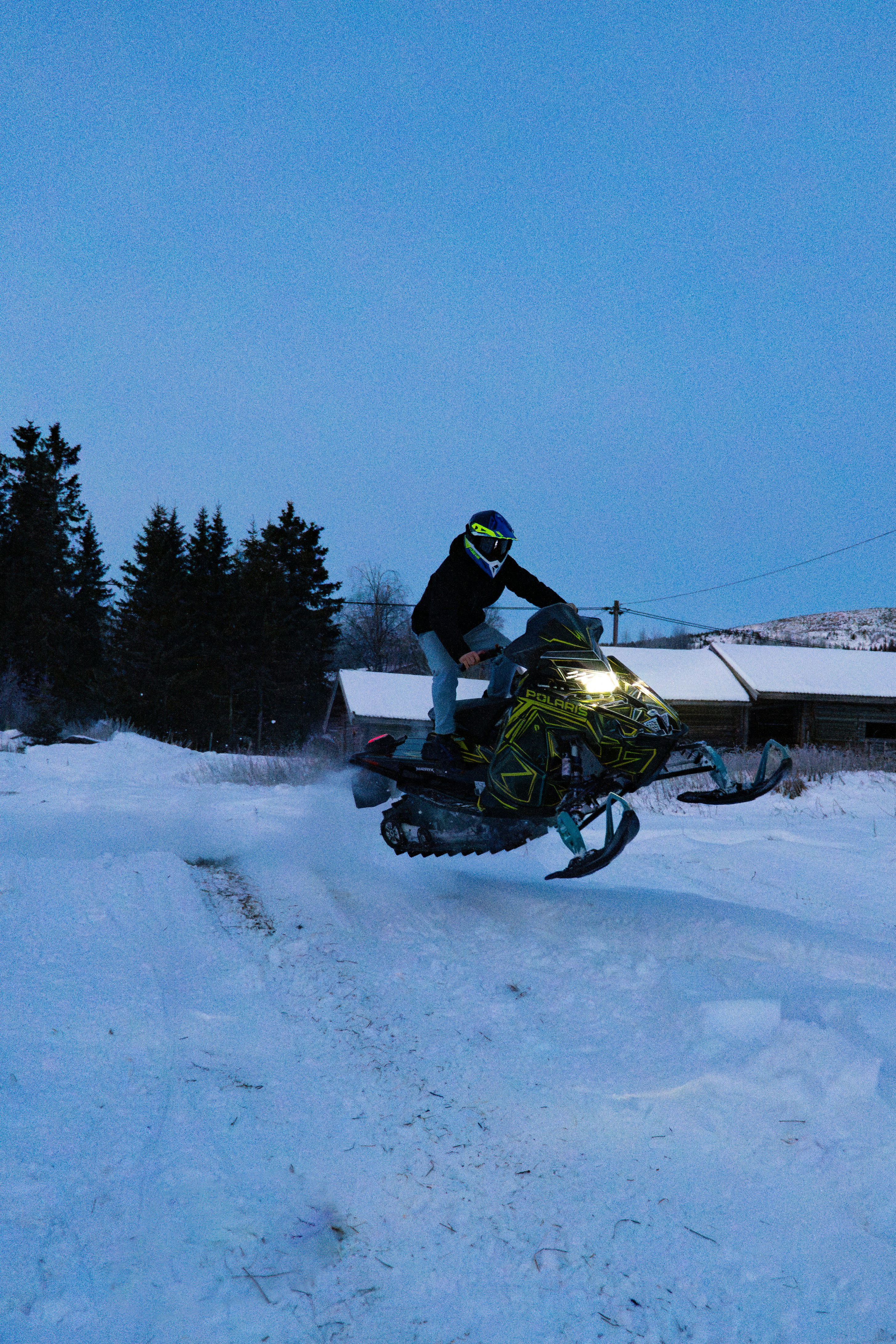 A man riding a snowmobile down a snow covered slope photo – Free Winter ...