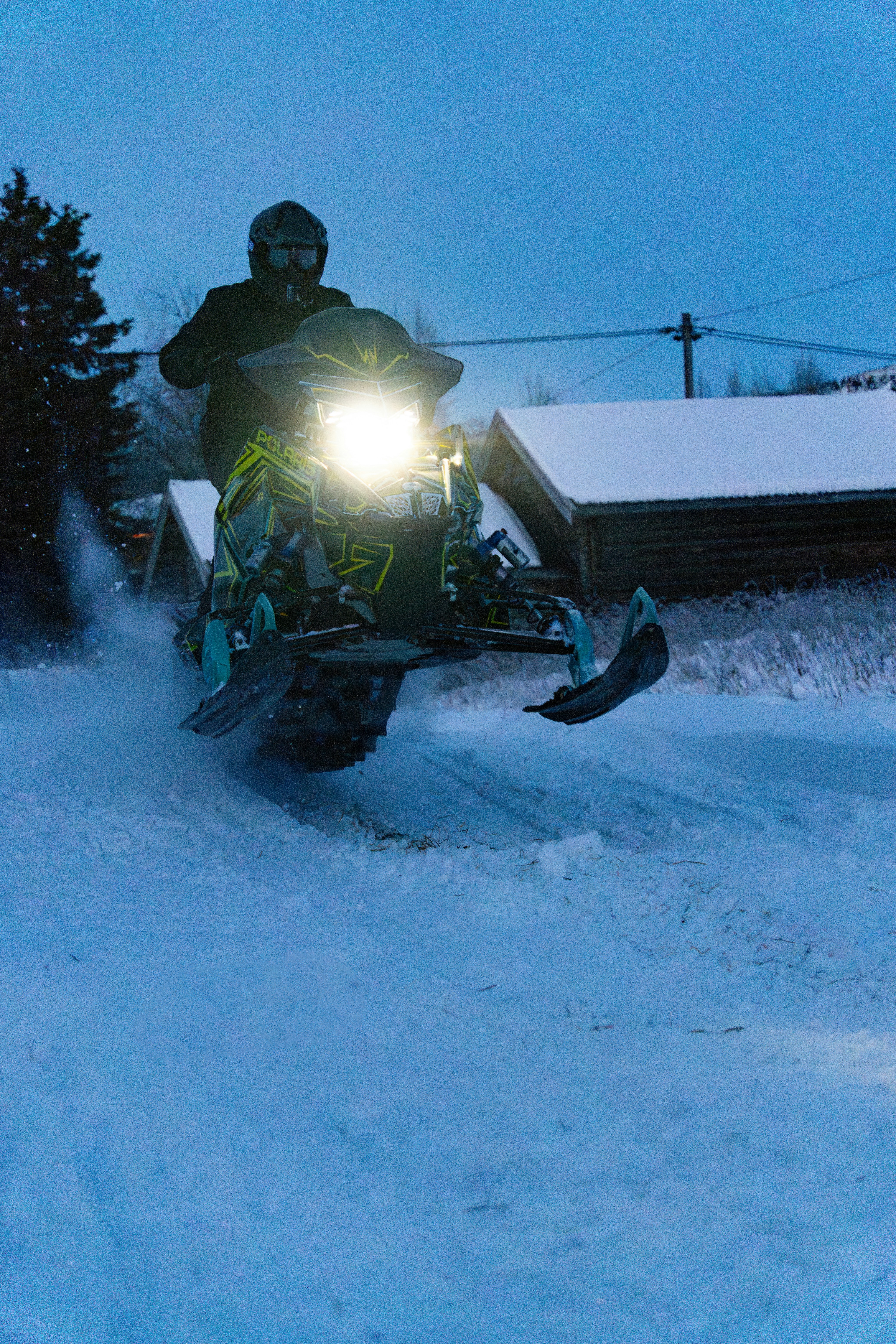 Headlight Bloom: Night Snowmobile Dash Through Blue Twilight
