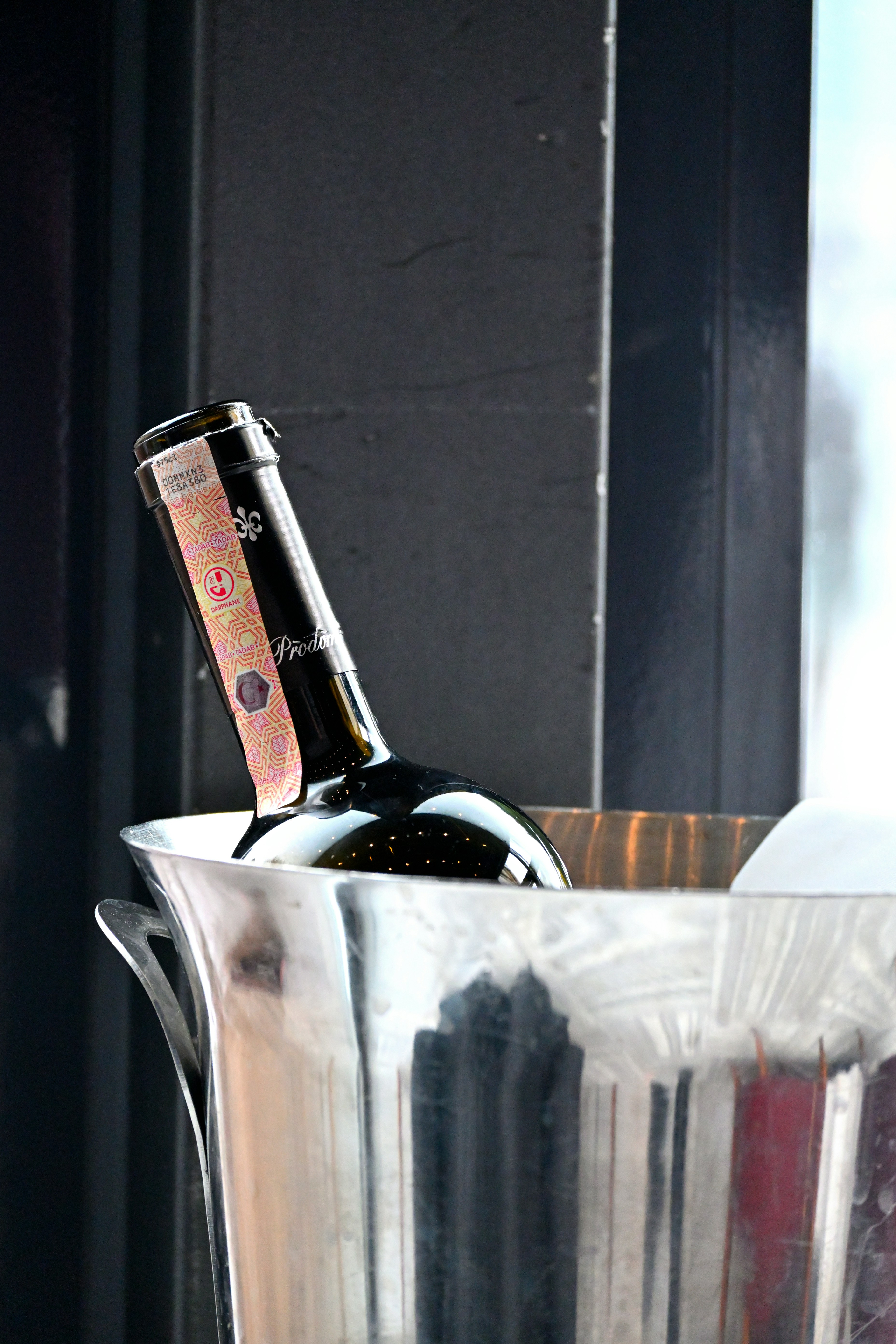 Neck of Noir: Wine Bottle Leaning in a Gleaming Ice Bucket