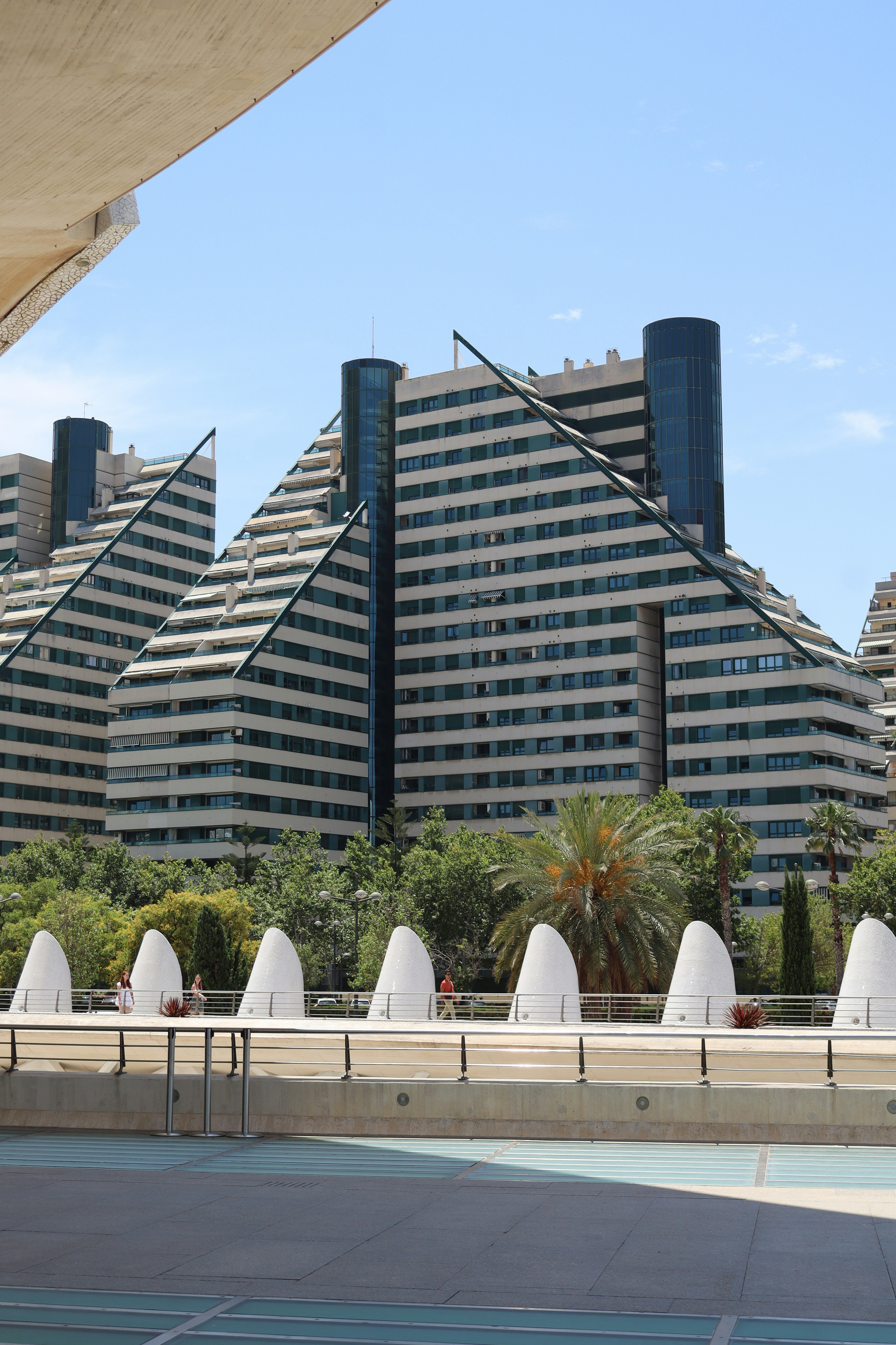 Chevron Peaks Over the Plaza: Geometric Towers Framing a Palm-Lined Forecourt