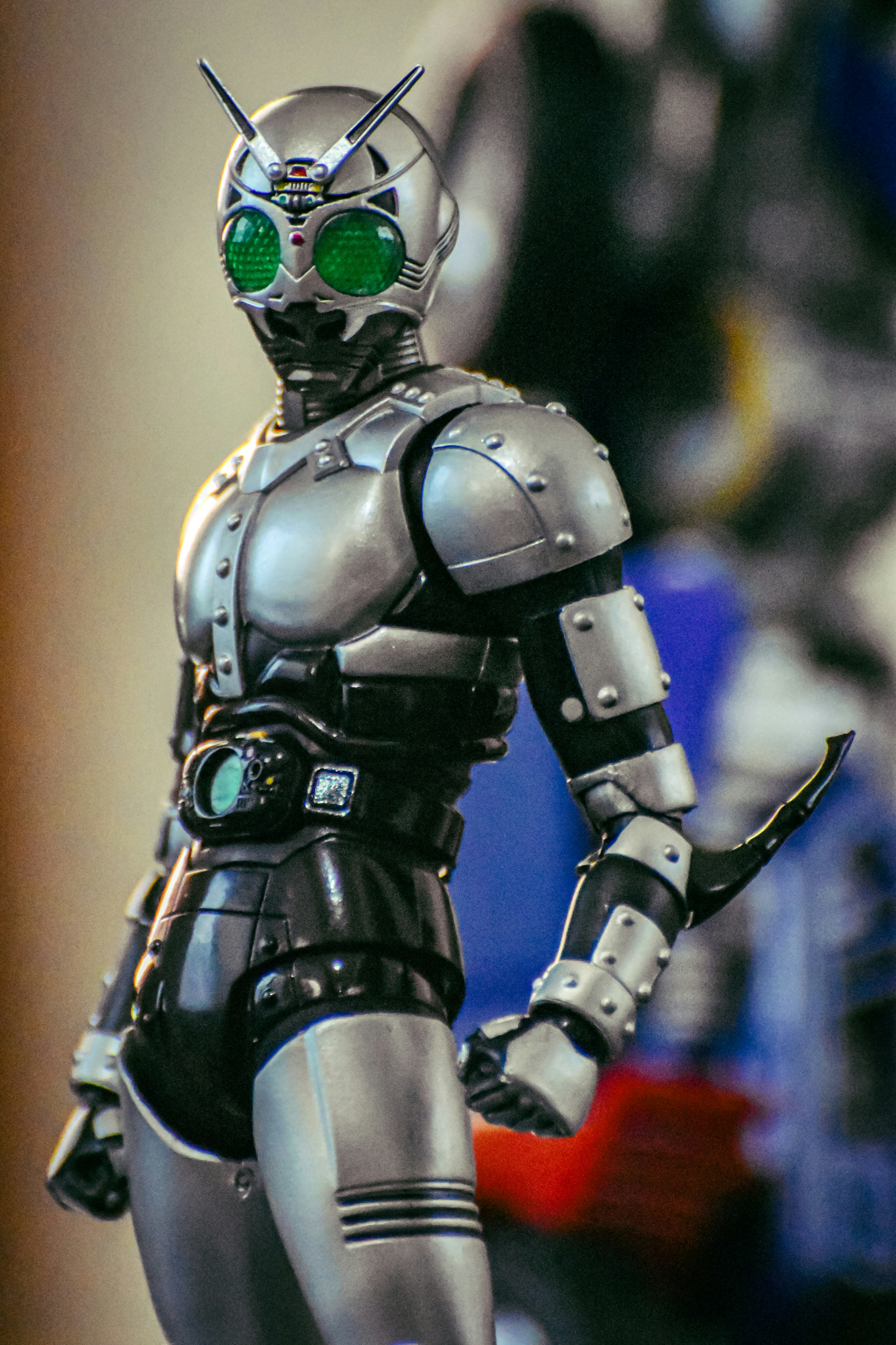 Detailed action figure of a silver-clad hero with green eyes, poised in a dynamic stance against a blurred background.