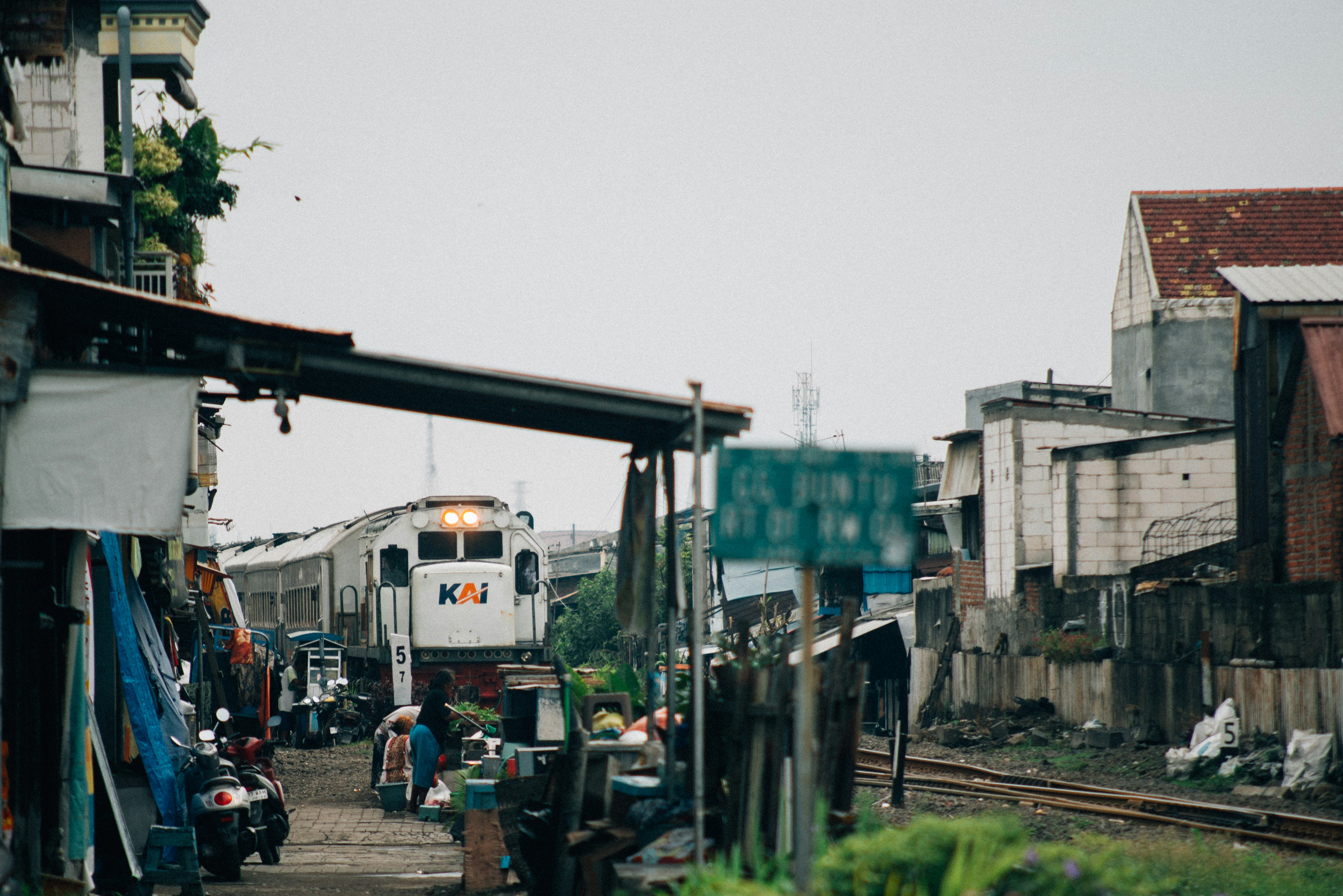 A train traveling down train tracks next to buildings photo – Free ...