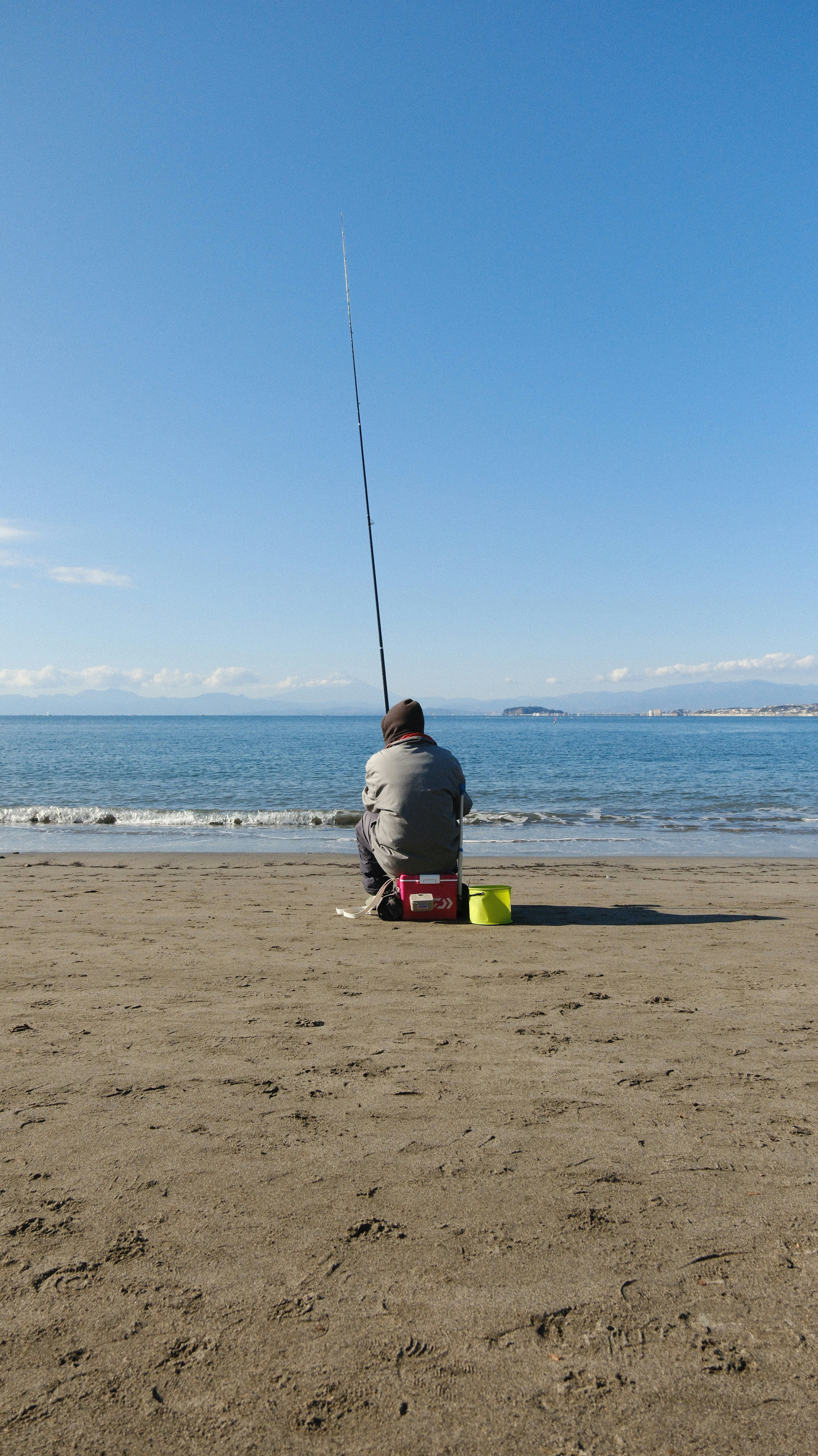 Line to the Horizon: A Solitary Angler on a Quiet Beach