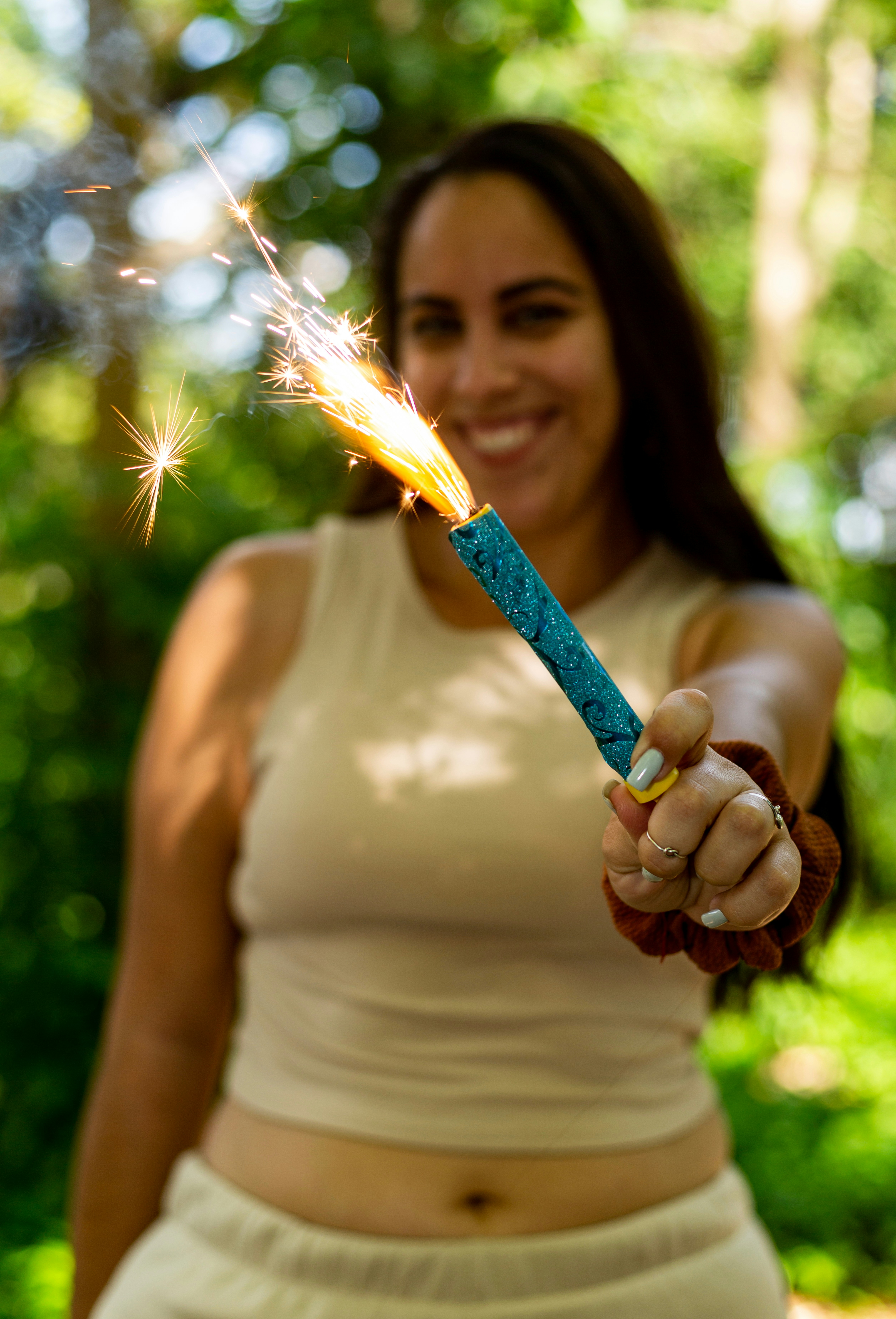 A woman holding a sparkler in her hand photo – Free Smile,fire,firework ...