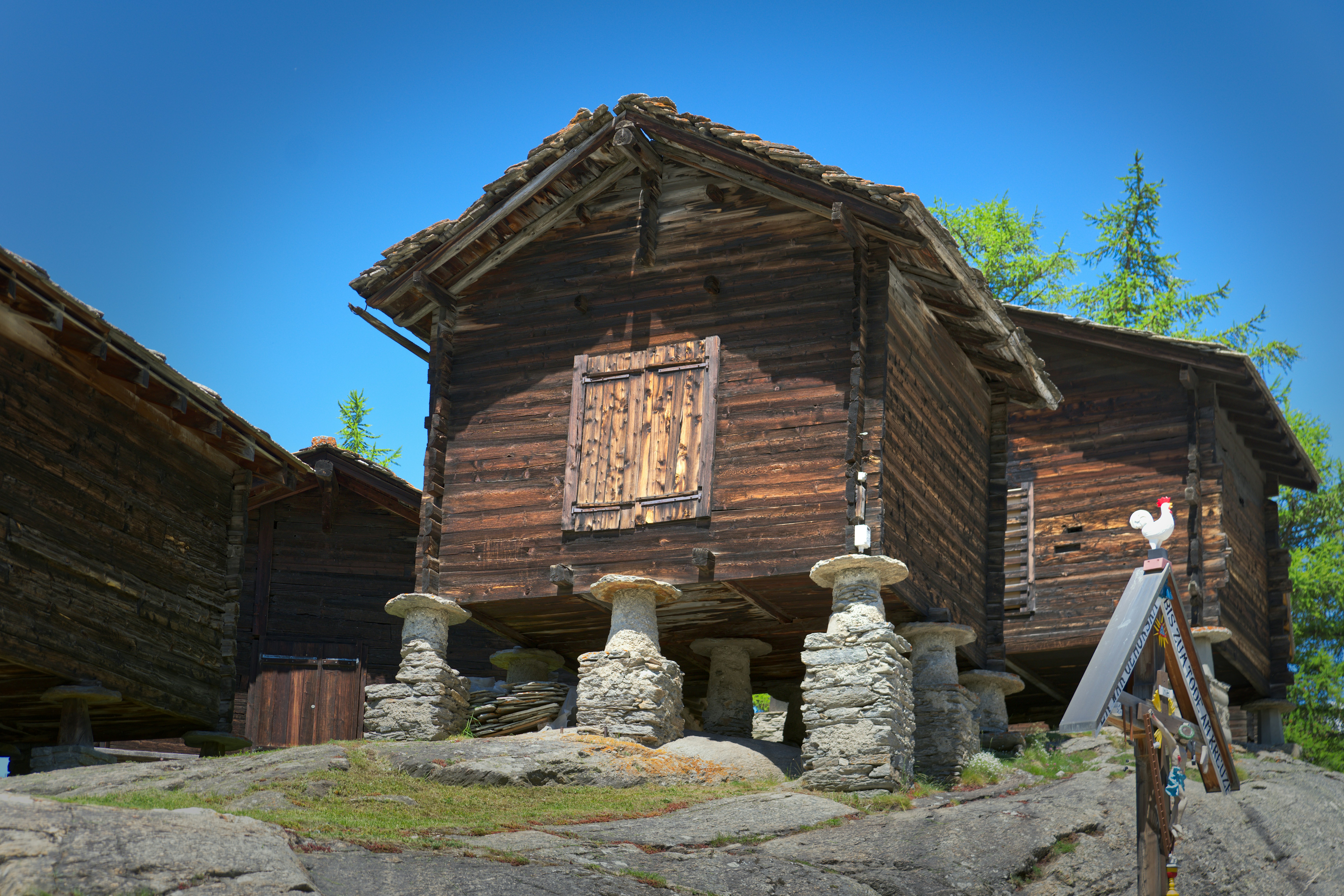 A log cabin with stone pillars and a flag pole photo – Free Building ...