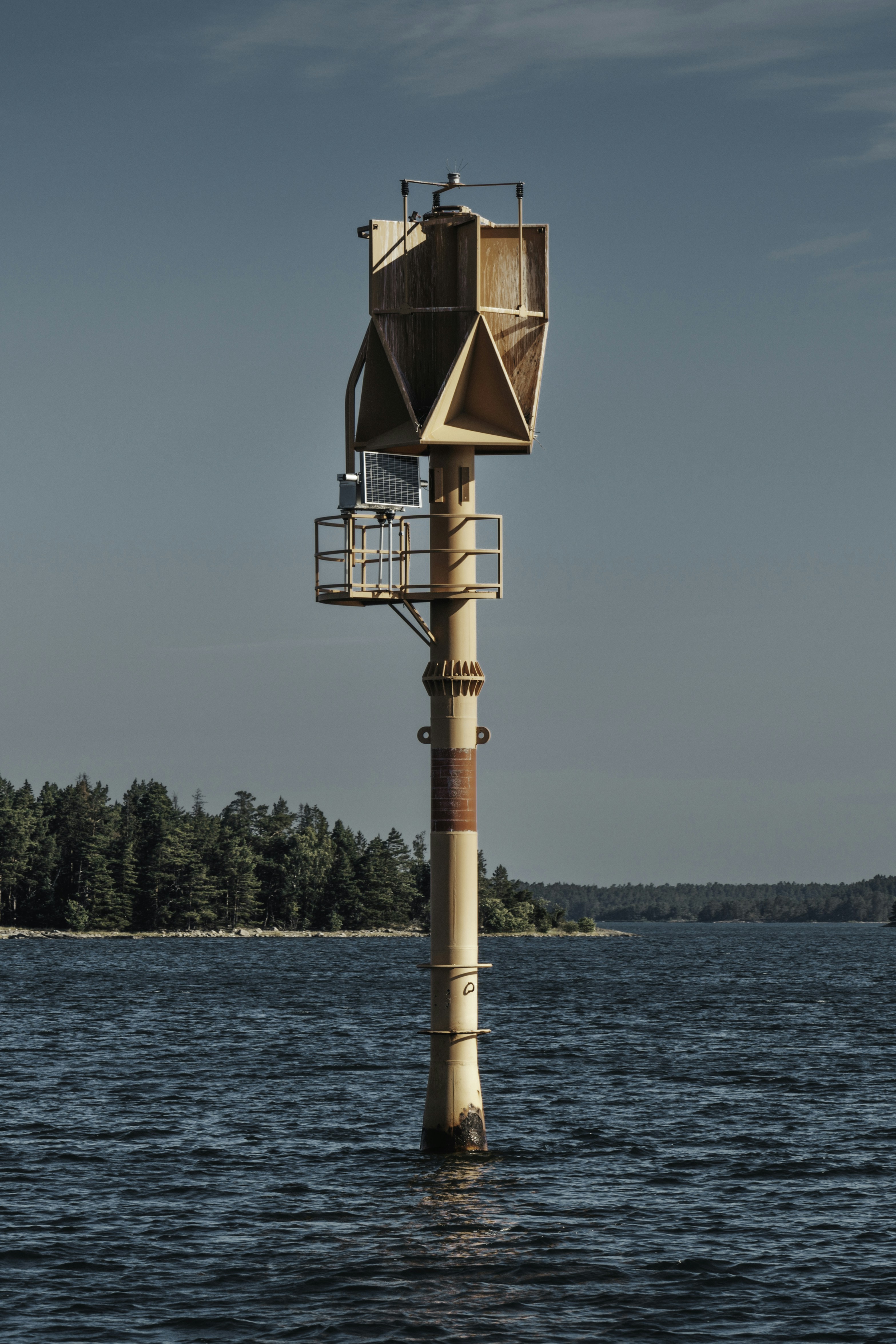 Rusted Beacon Over Quiet Waters: A Maritime Sentinel Framed by Pines