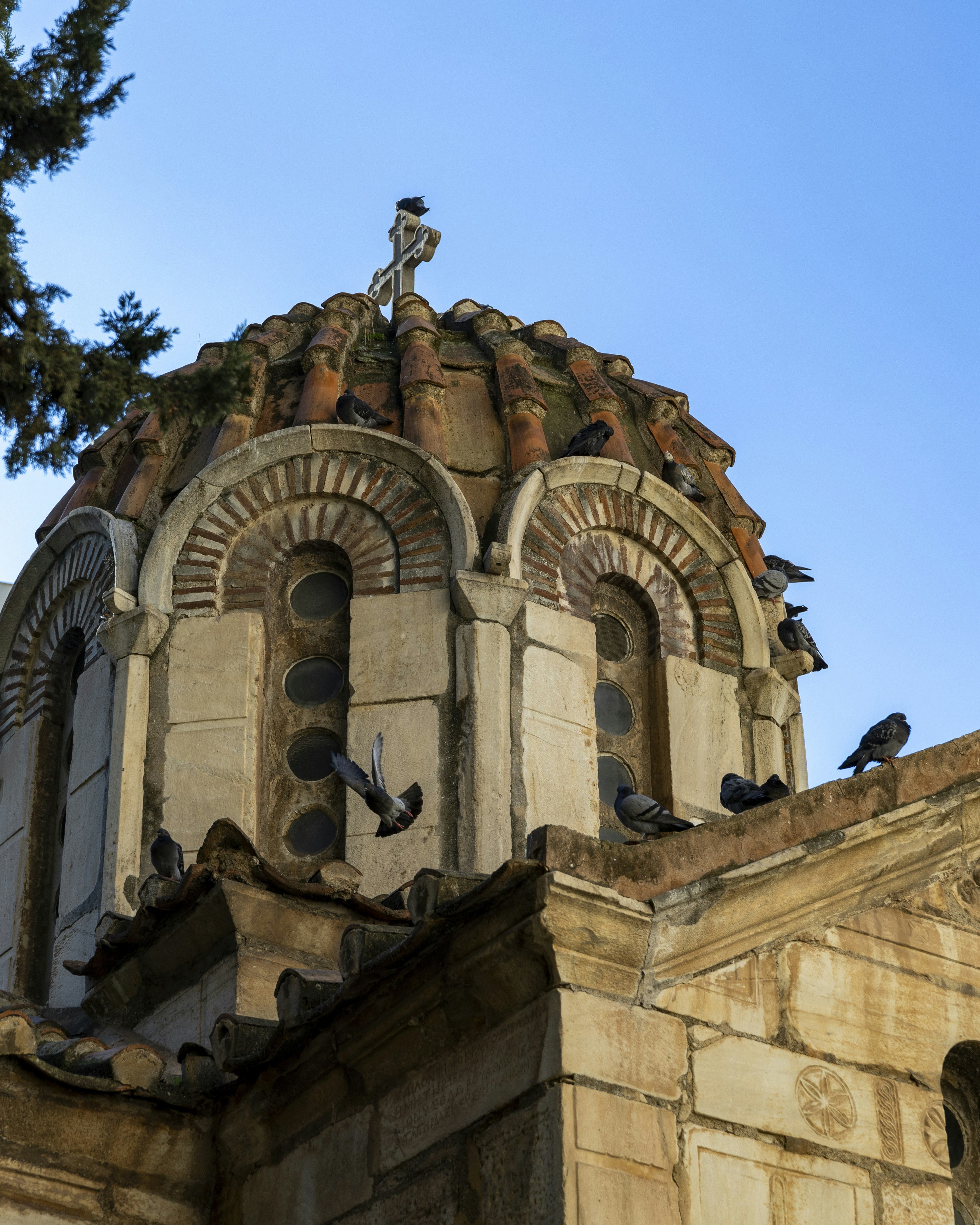 Cross Crest and Pigeons: Weathered Dome Against a Clear Blue Sky