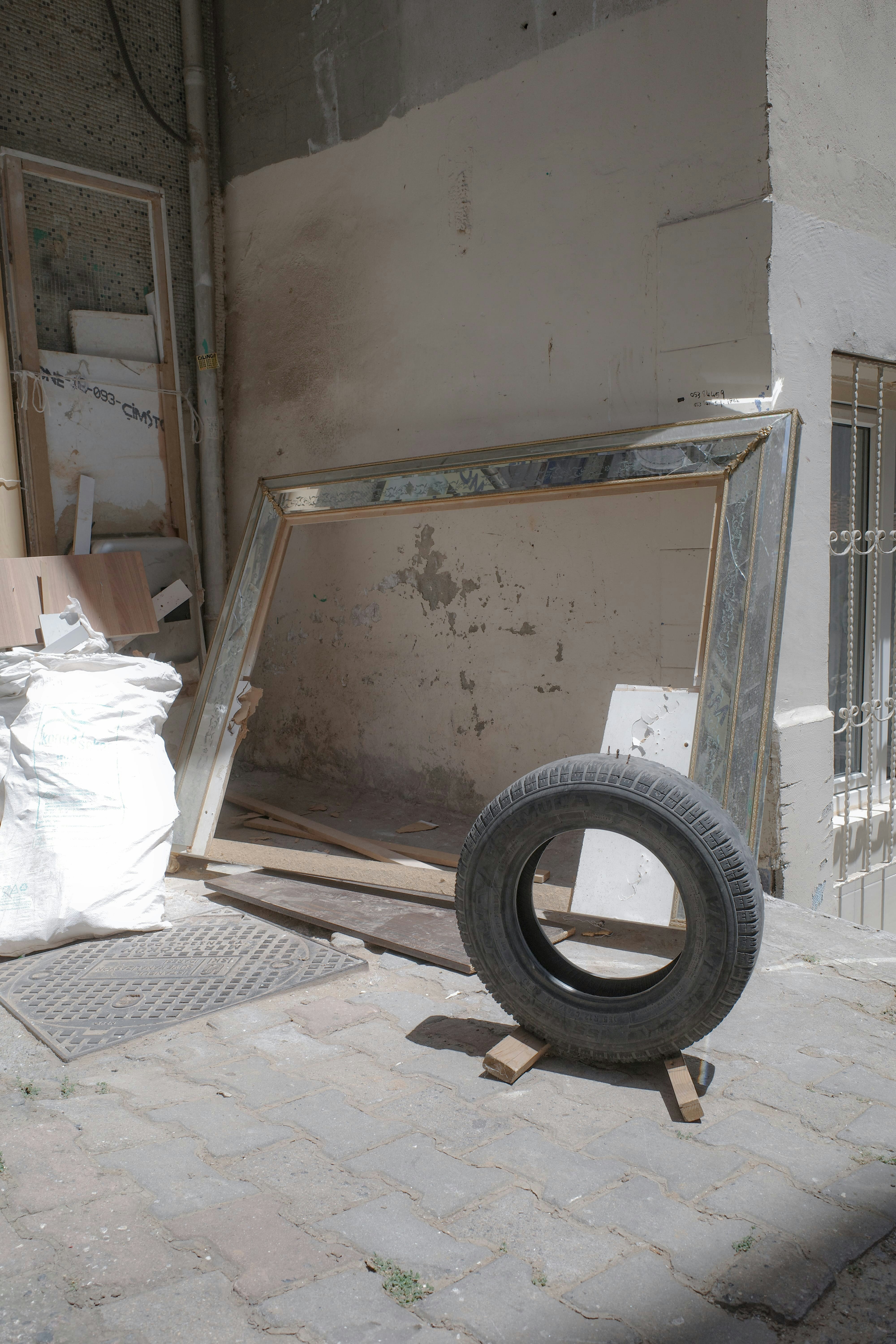 A tire sitting on the ground in front of a building photo – Free ...