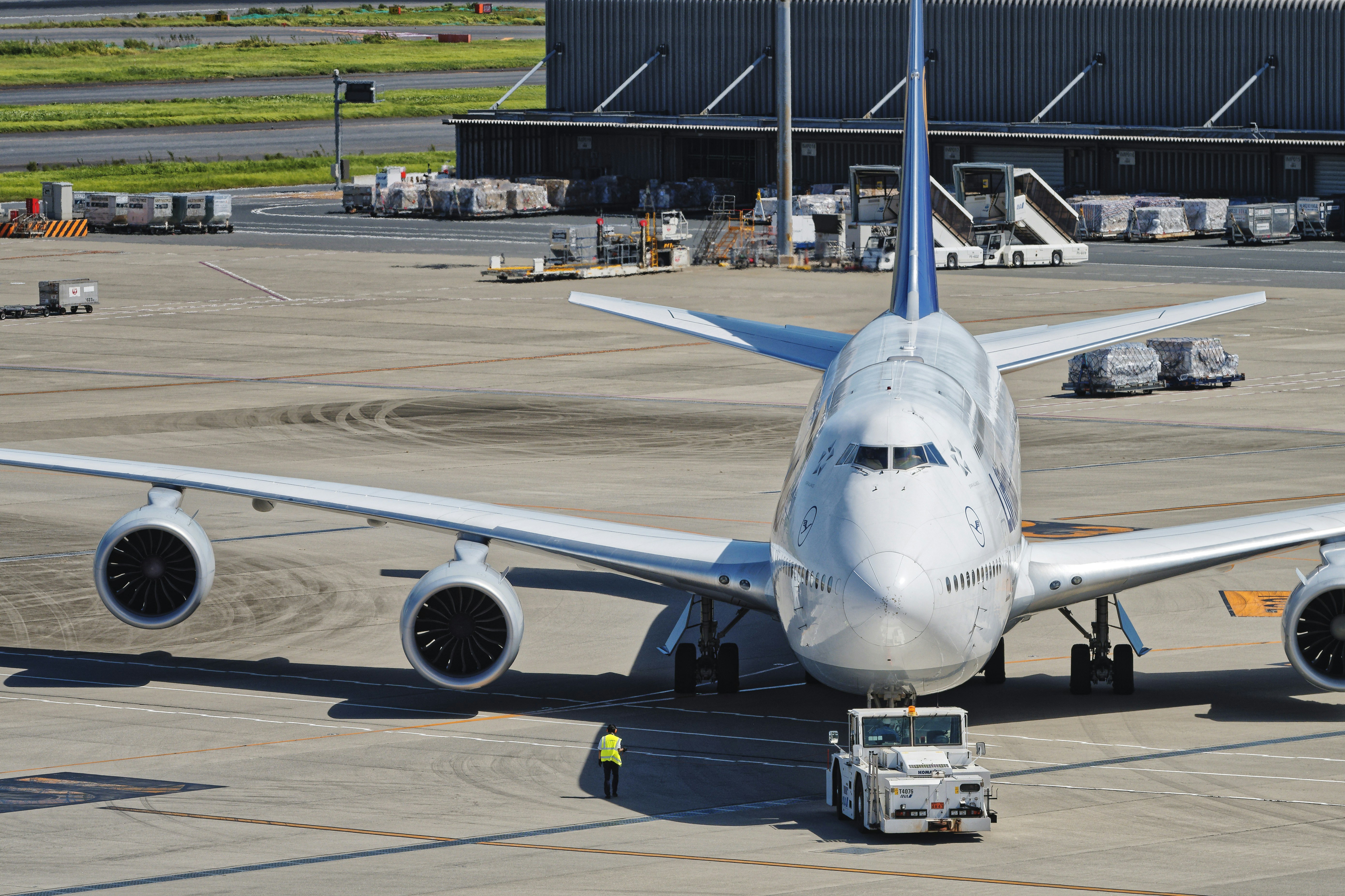 Jumbo jet on the tarmac with gleaming engines and vibrant colors against a muted backdrop.