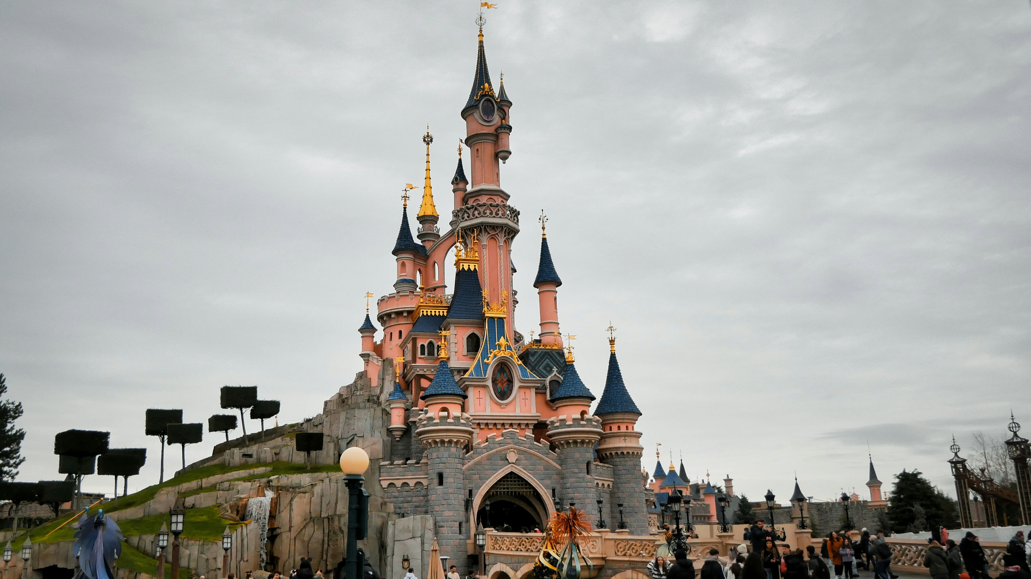 Pastel Spires on a Quiet Hill: A Fairy-Tale Castle Under Cloudy Skies