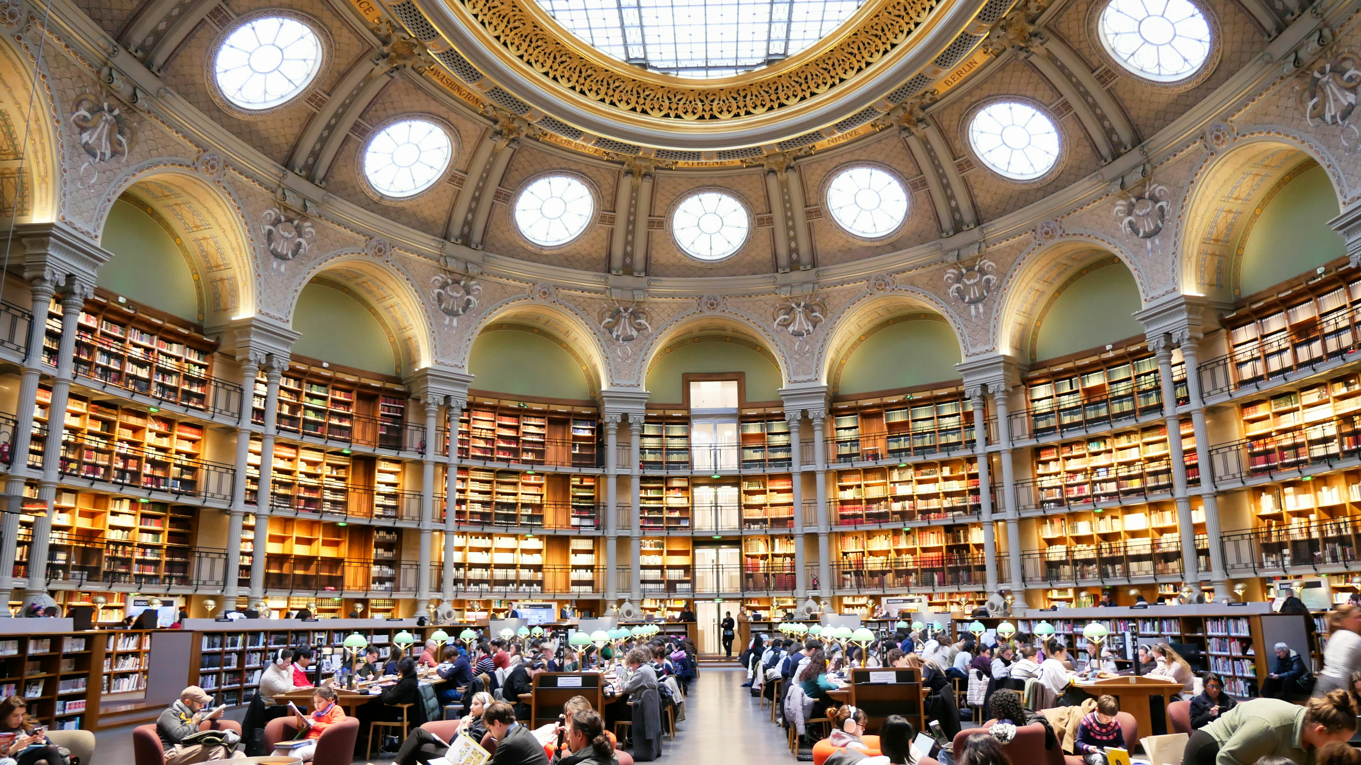 A large library filled with lots of books photo – Free Human Image on ...