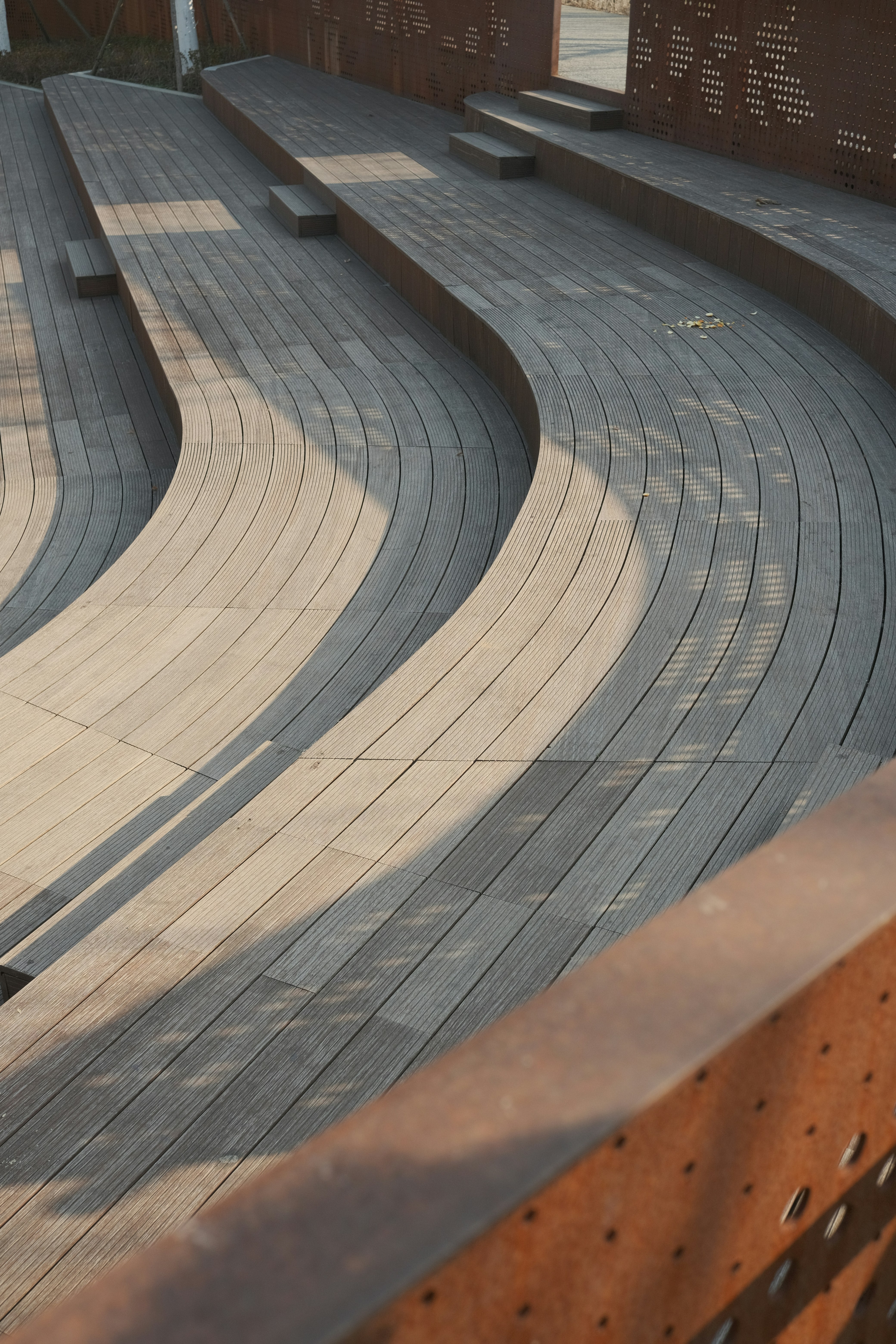Curved wooden steps in the sunlit plaza