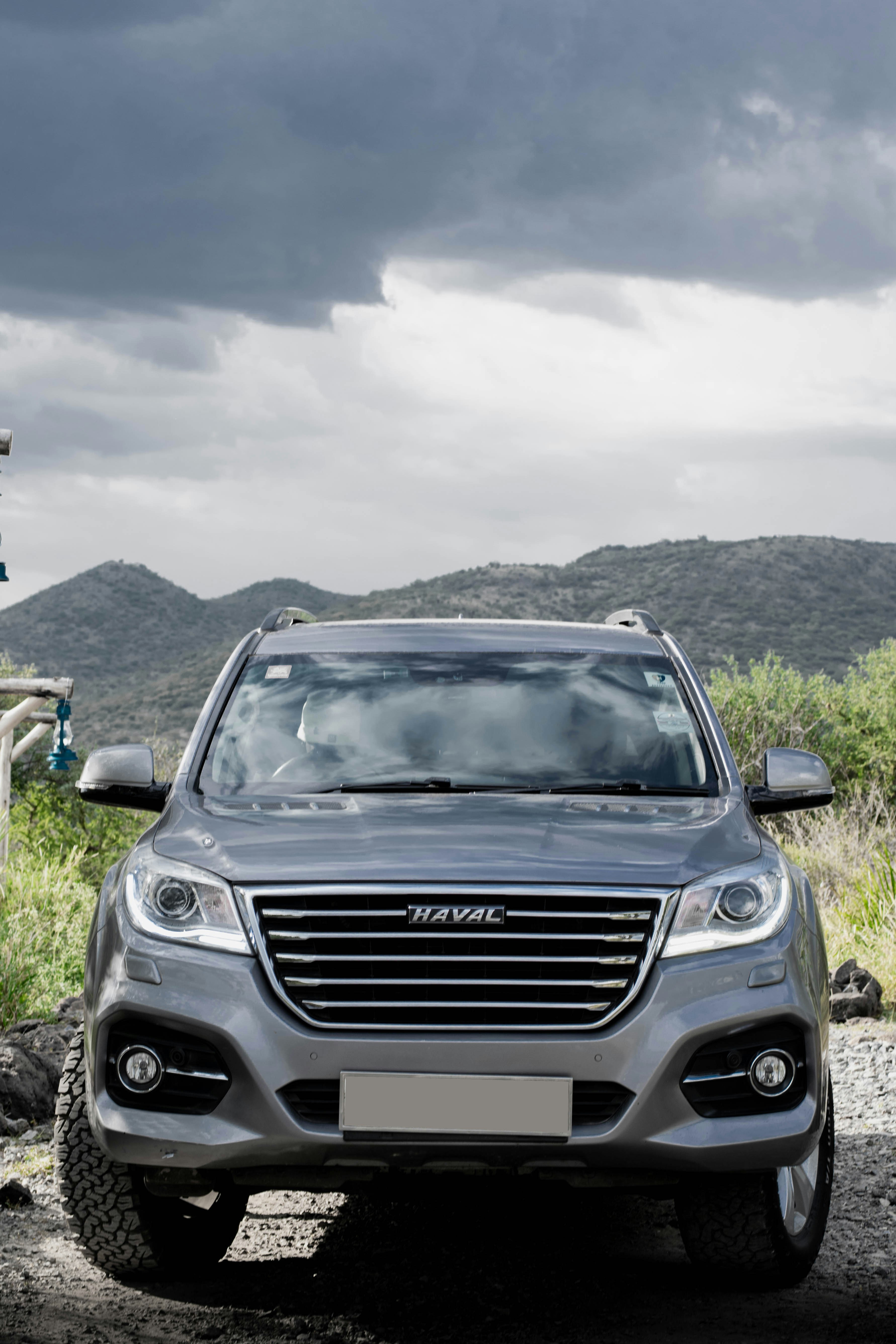Chrome Grille on the Ridge: A Haval SUV Anchored in a Rugged Overlook