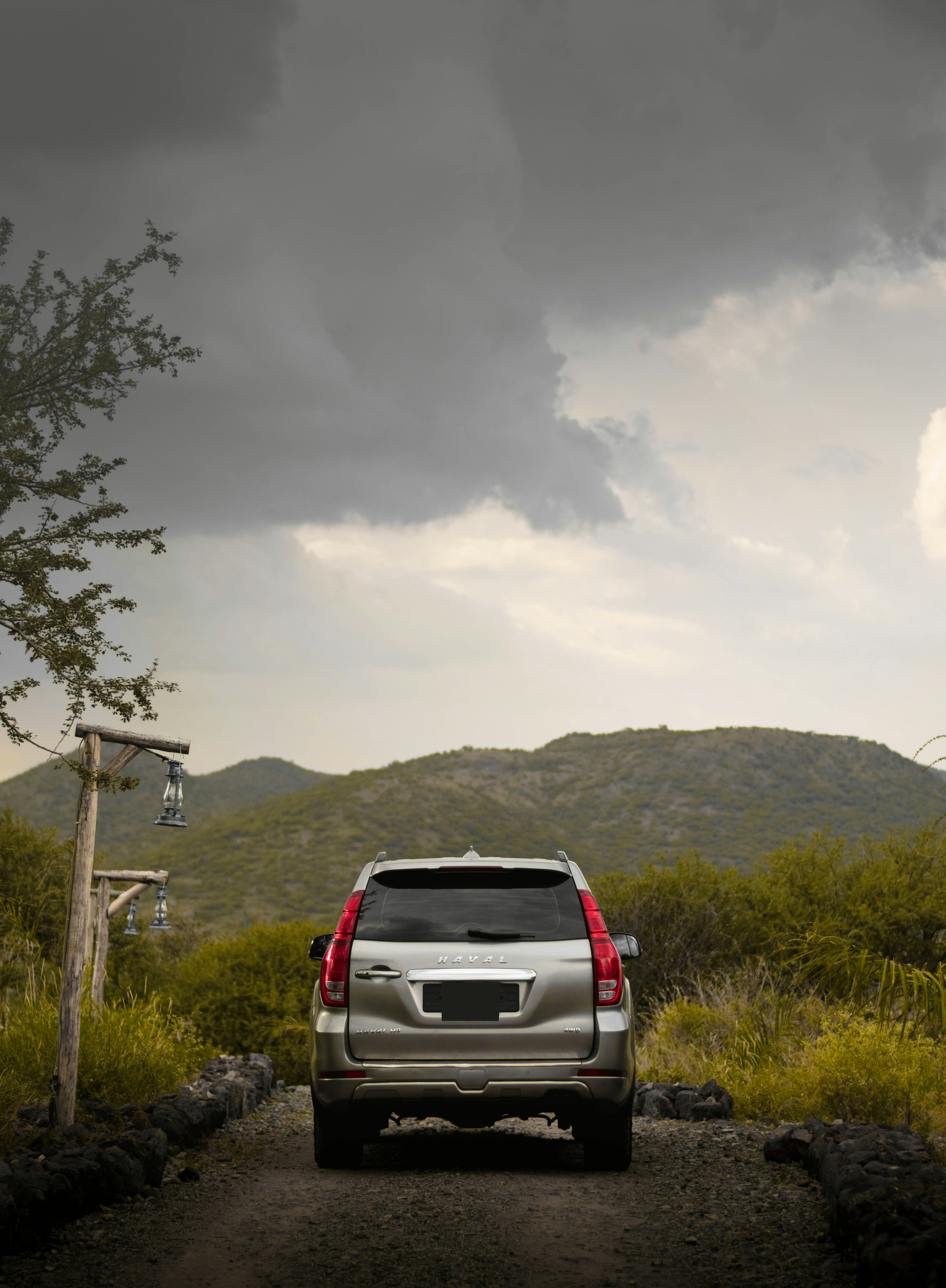 SUV on a Rain-Washed Road Beneath a Looming Storm