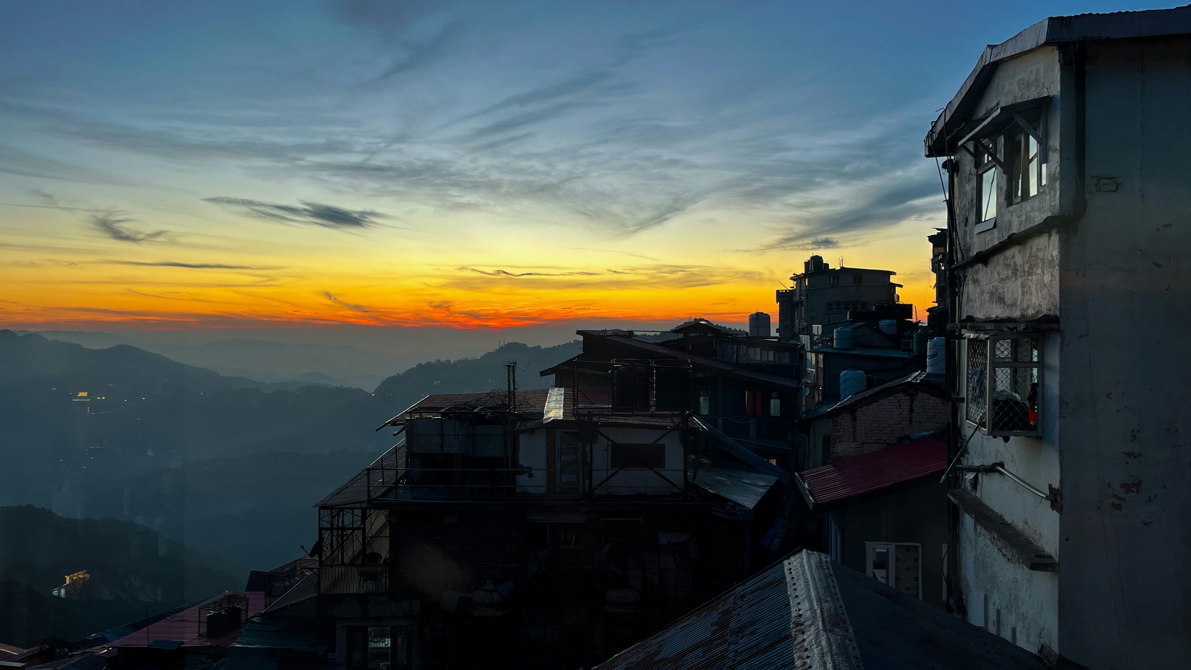 Ridgeline Sunset: Rooftops Silhouetted Against a Fiery Horizon