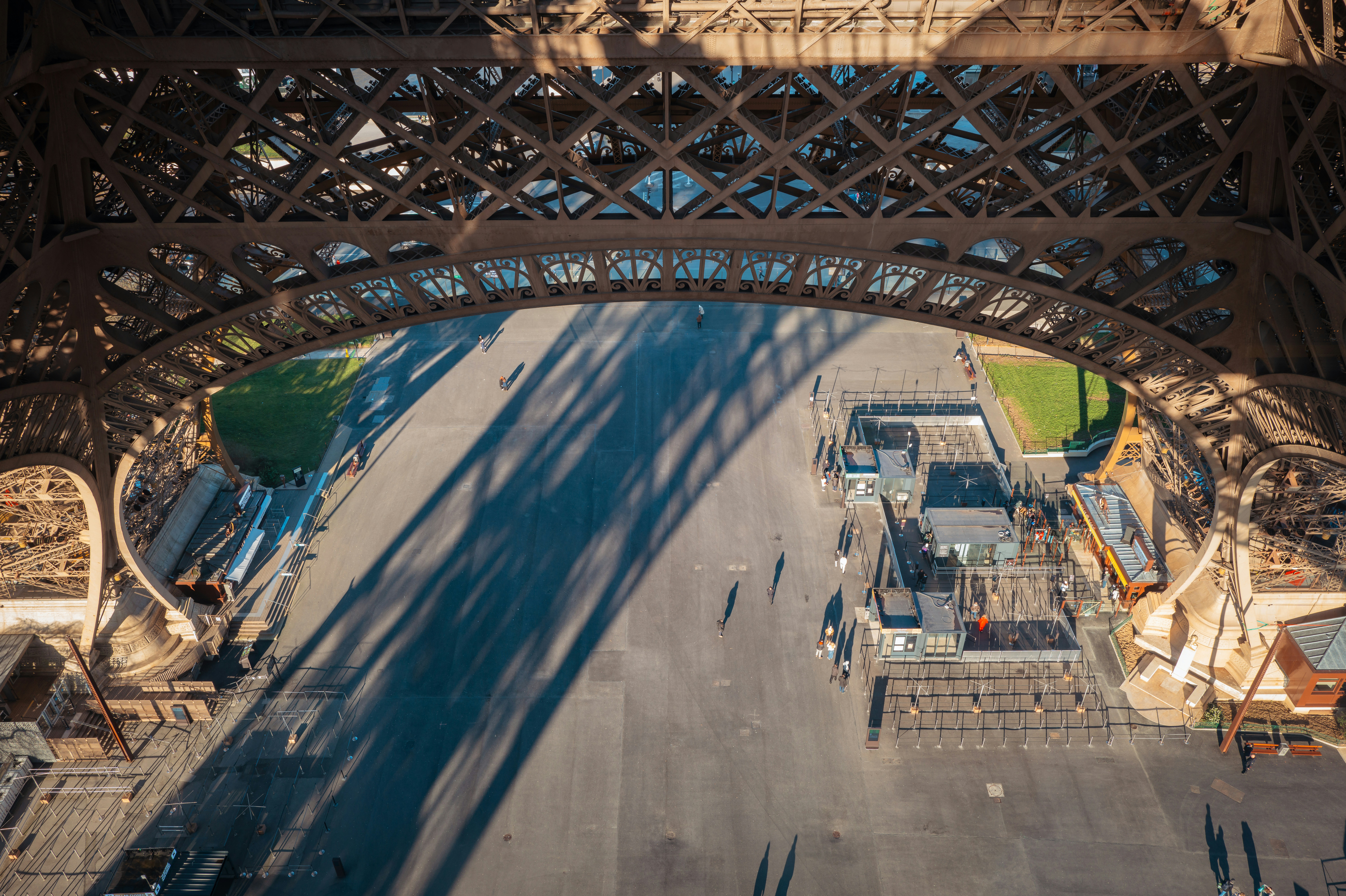 Under the Iron Lace: A Street Scene Framed by Lattice Shadows