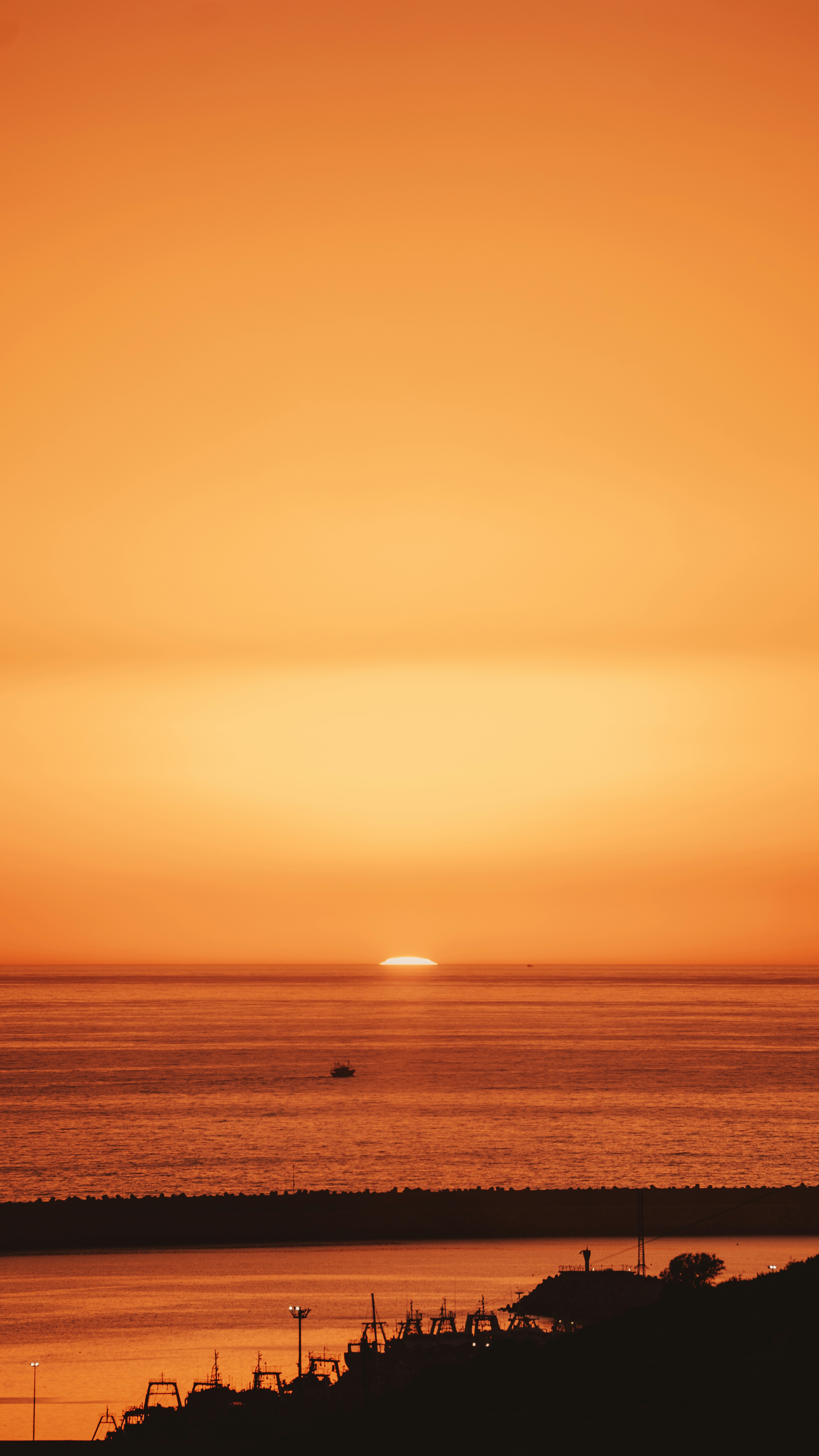 Crimson Horizon Over a Silent Harbor at Sunset